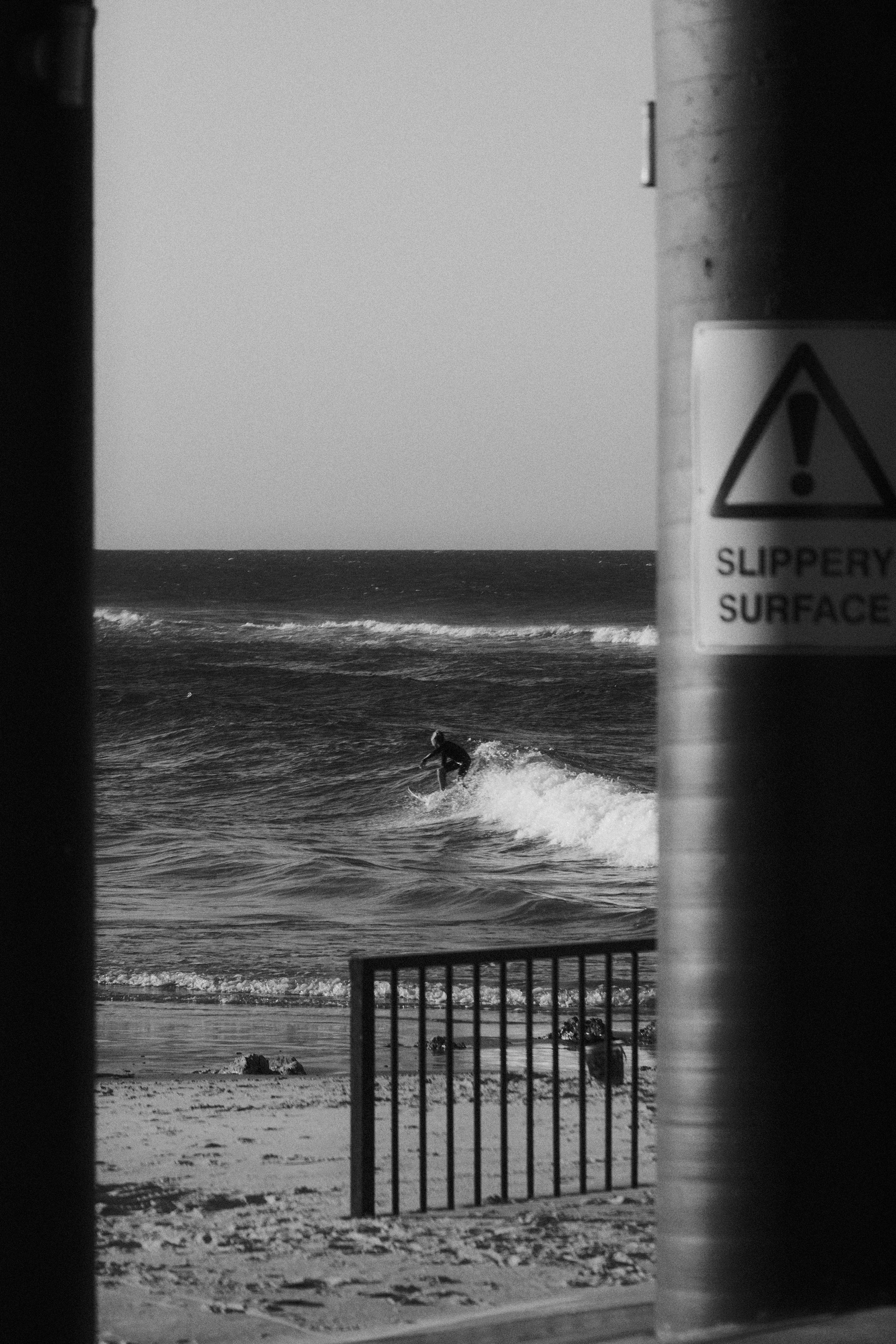 Surfer in the Gap Between Pillars