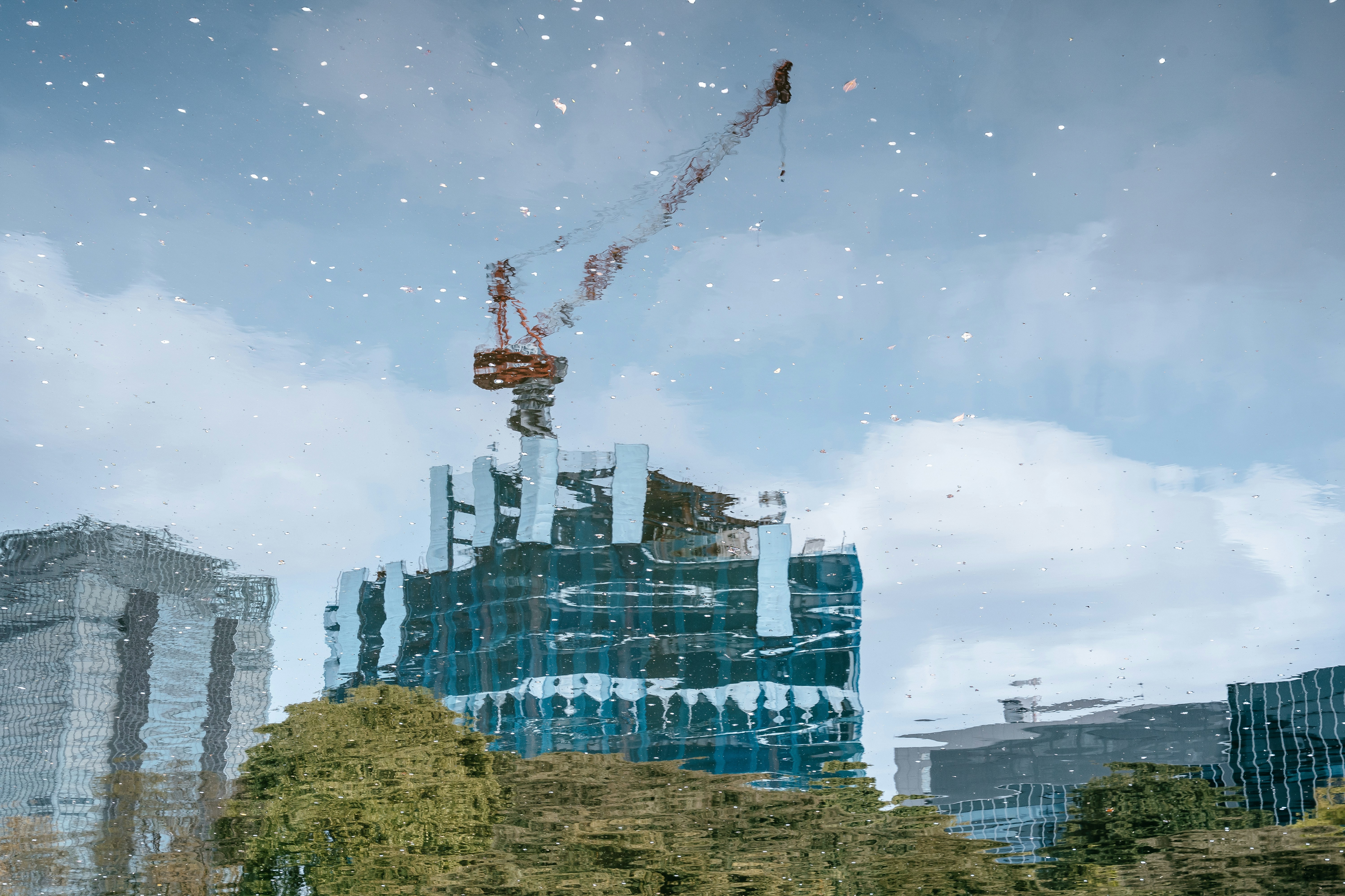 Urban Mirror: Crane and Tower Reflections in Glass Facade Atmosphere