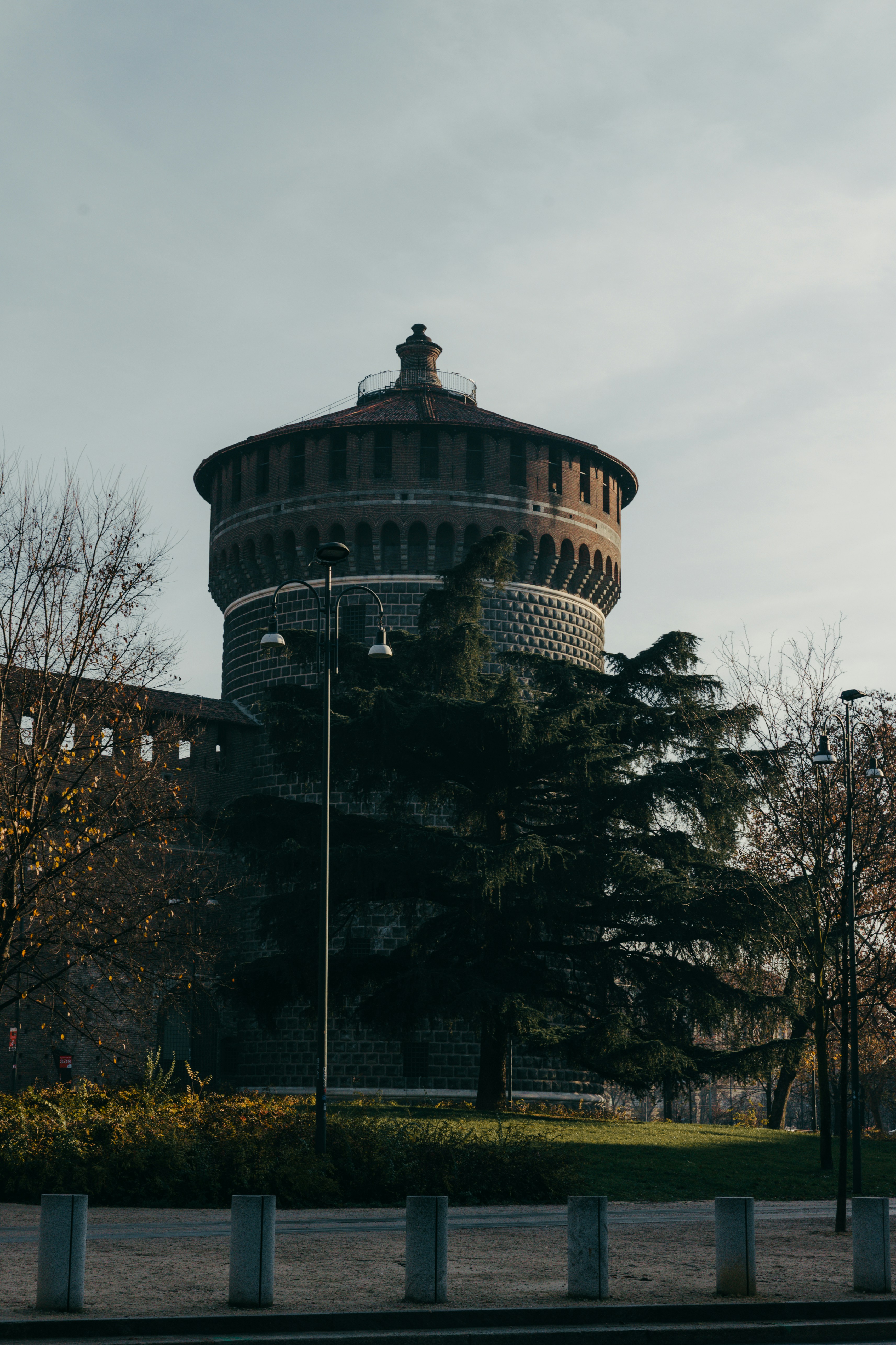 Stone Watchtower Among Bare Trees at Dusk