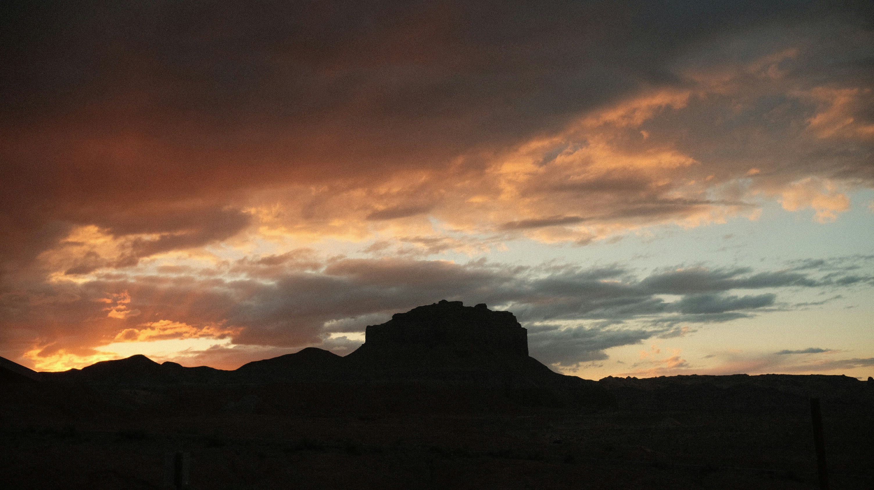 Silhouette Against a Painted Sunset Over a Desert Plateau