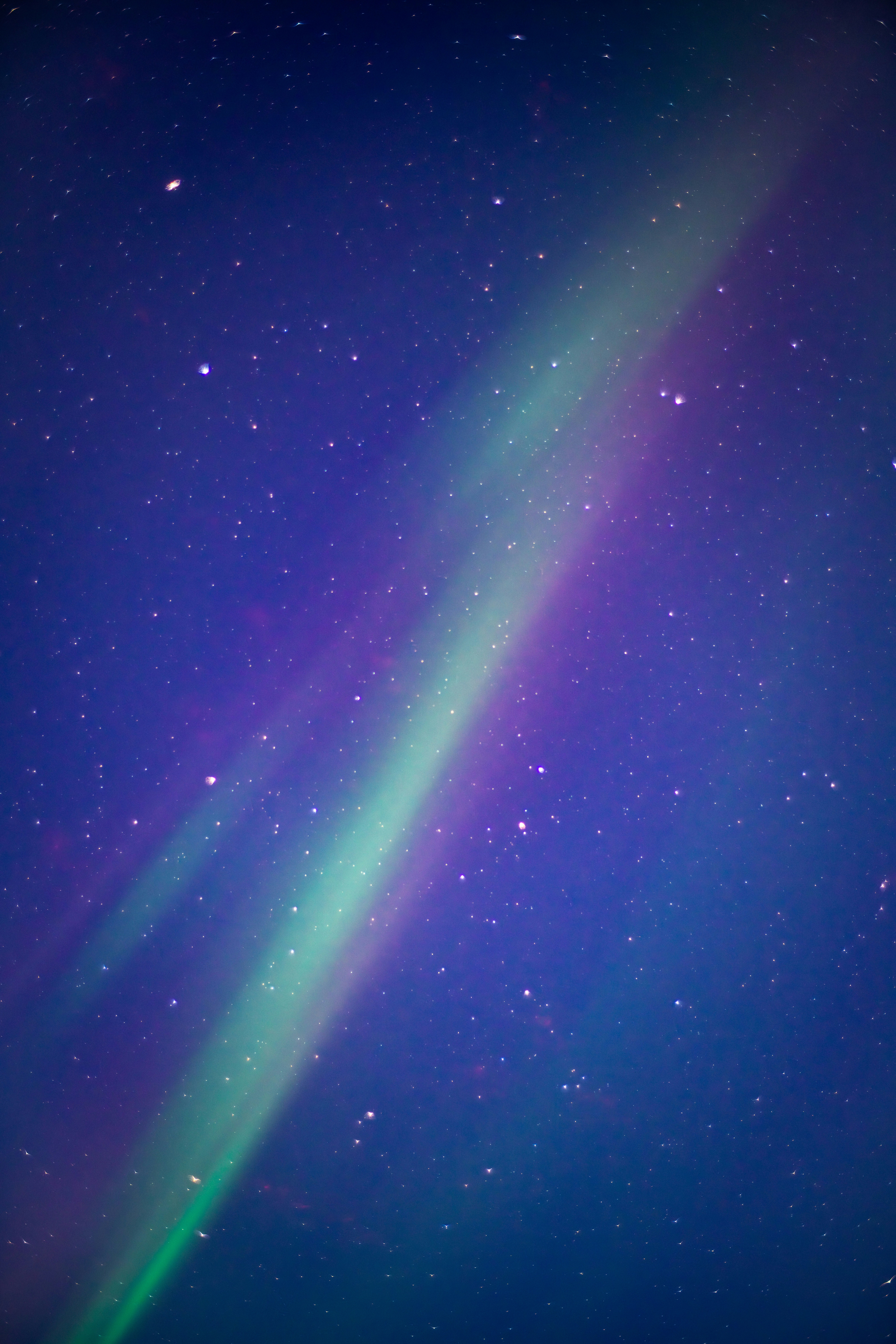 Green and purple northern lights illuminate a starry night sky. photo ...