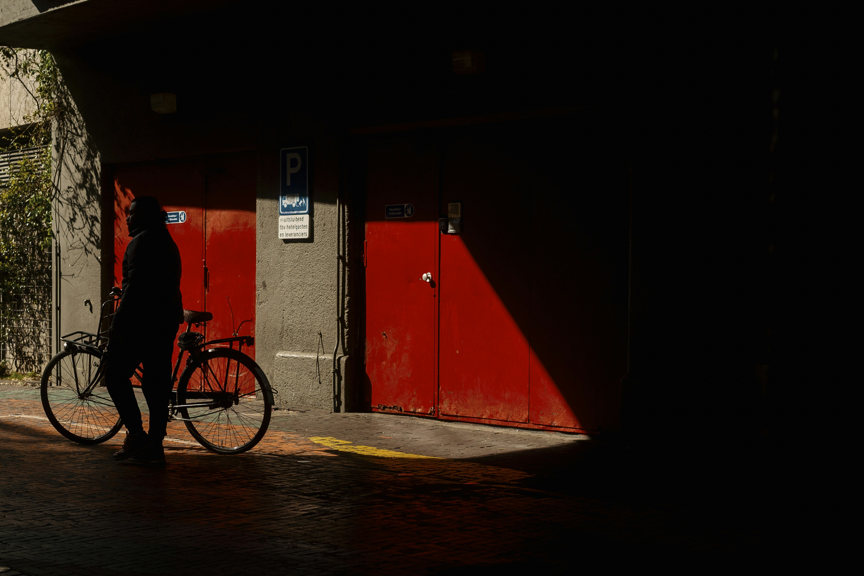 Bicycle silhouette in a shadowed doorway under a sunlit doorway edge