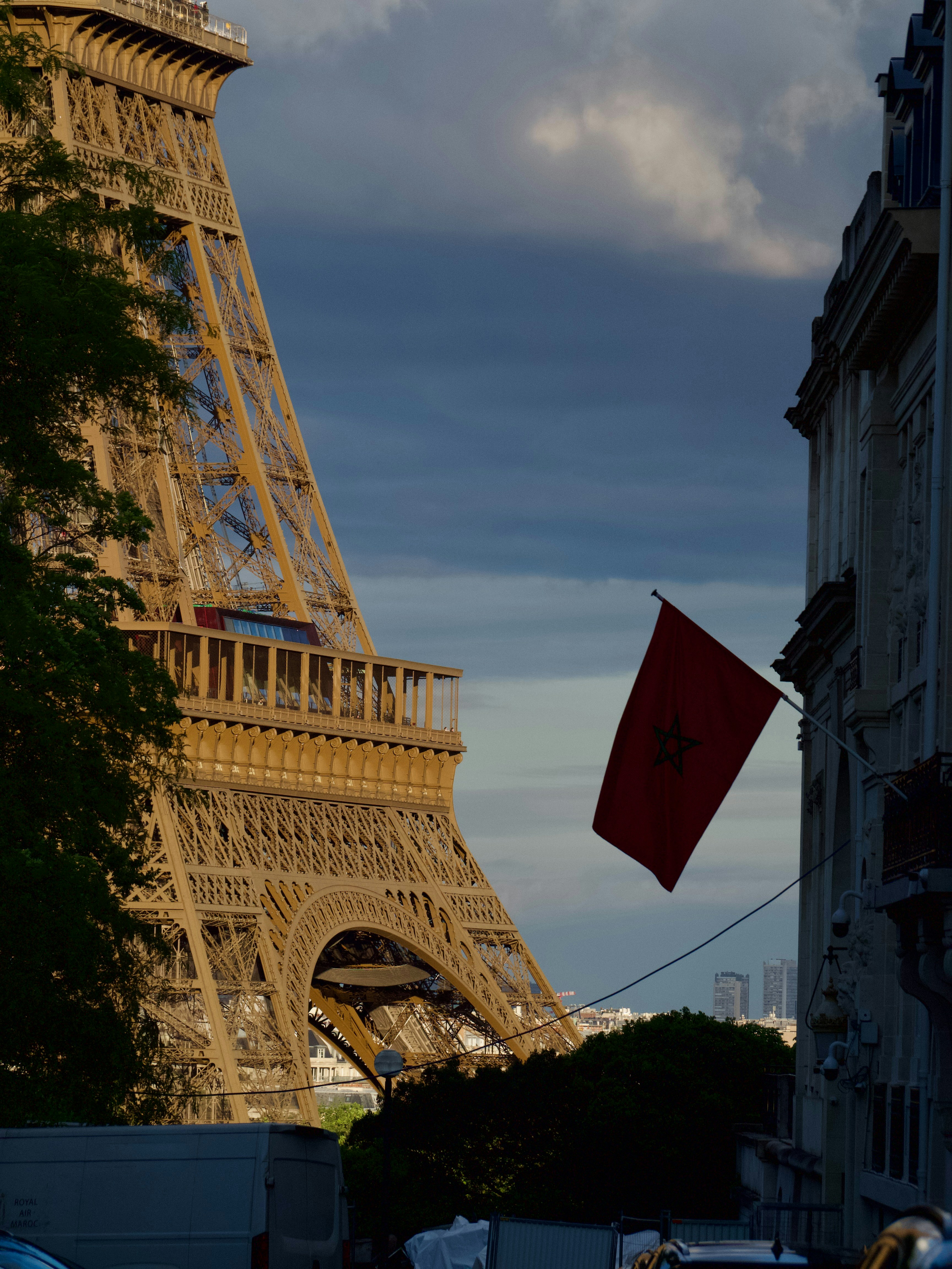 Paris in Silhouette: Towering Iron and a Flag in the City’s Shadow