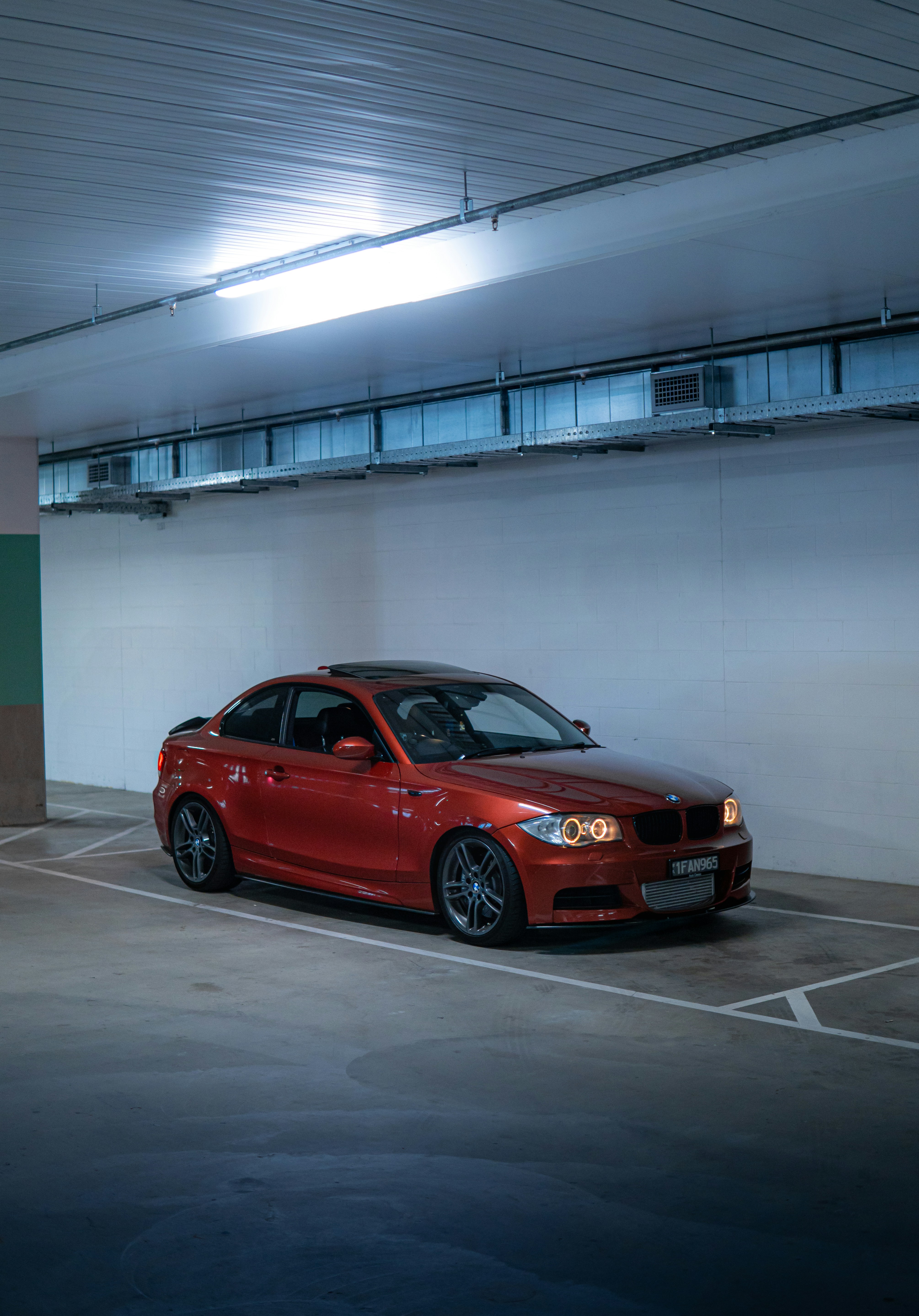 Red BMW in an Empty Parking Garage Under Cool Neon Glow