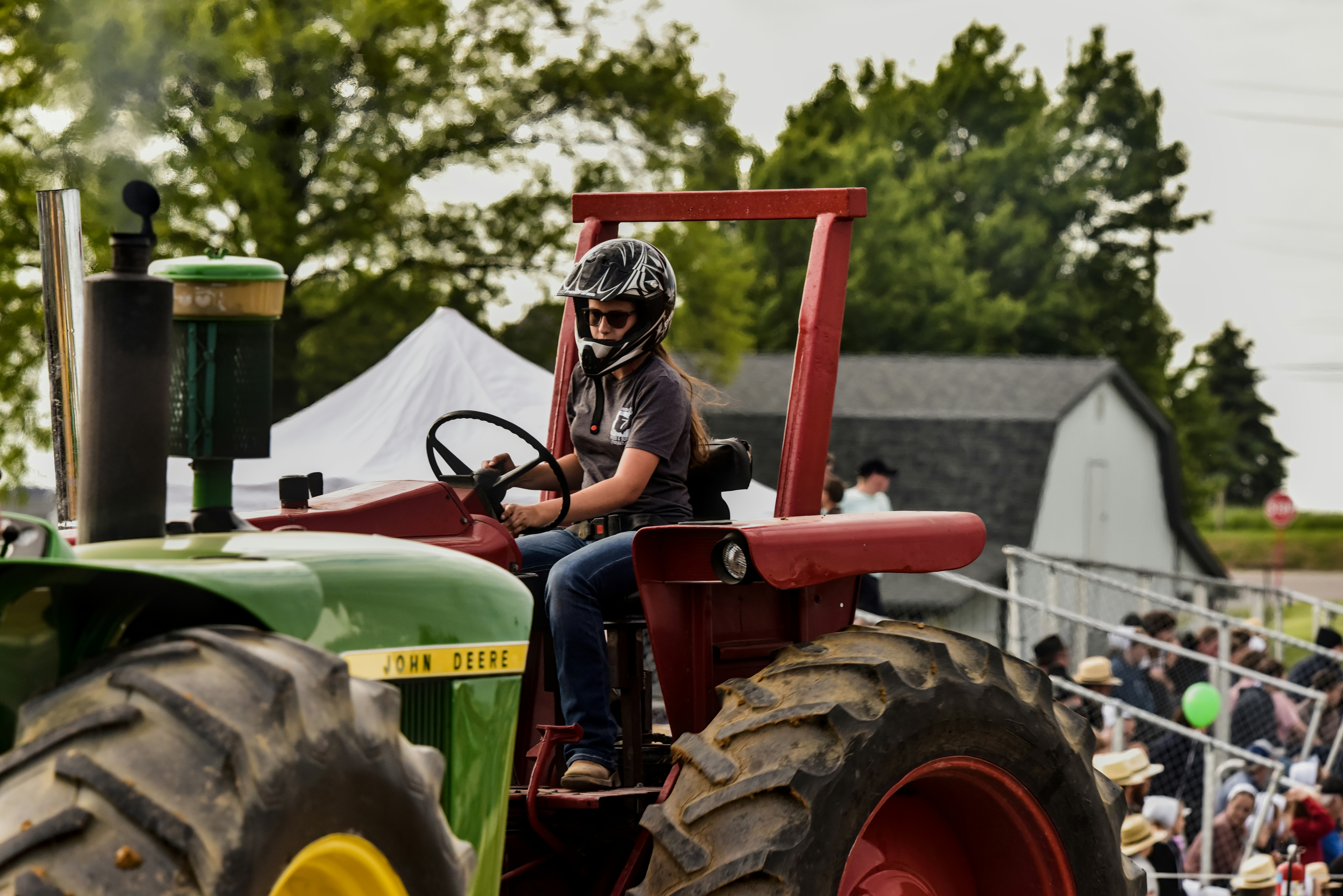 Driver in a vintage tractor at a community fair.