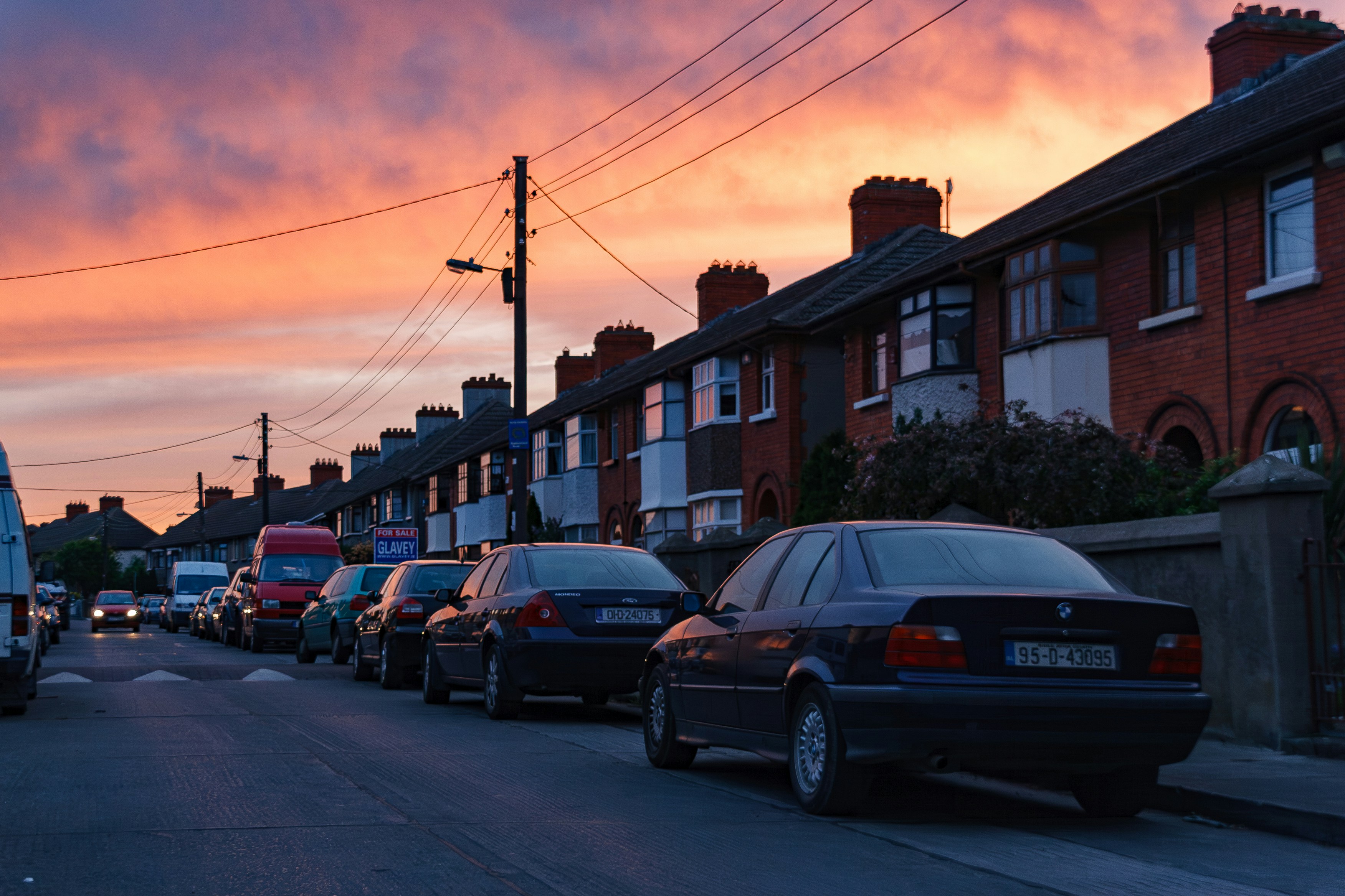 Evening Crest: Cars Line a Quiet Street at Sundown
