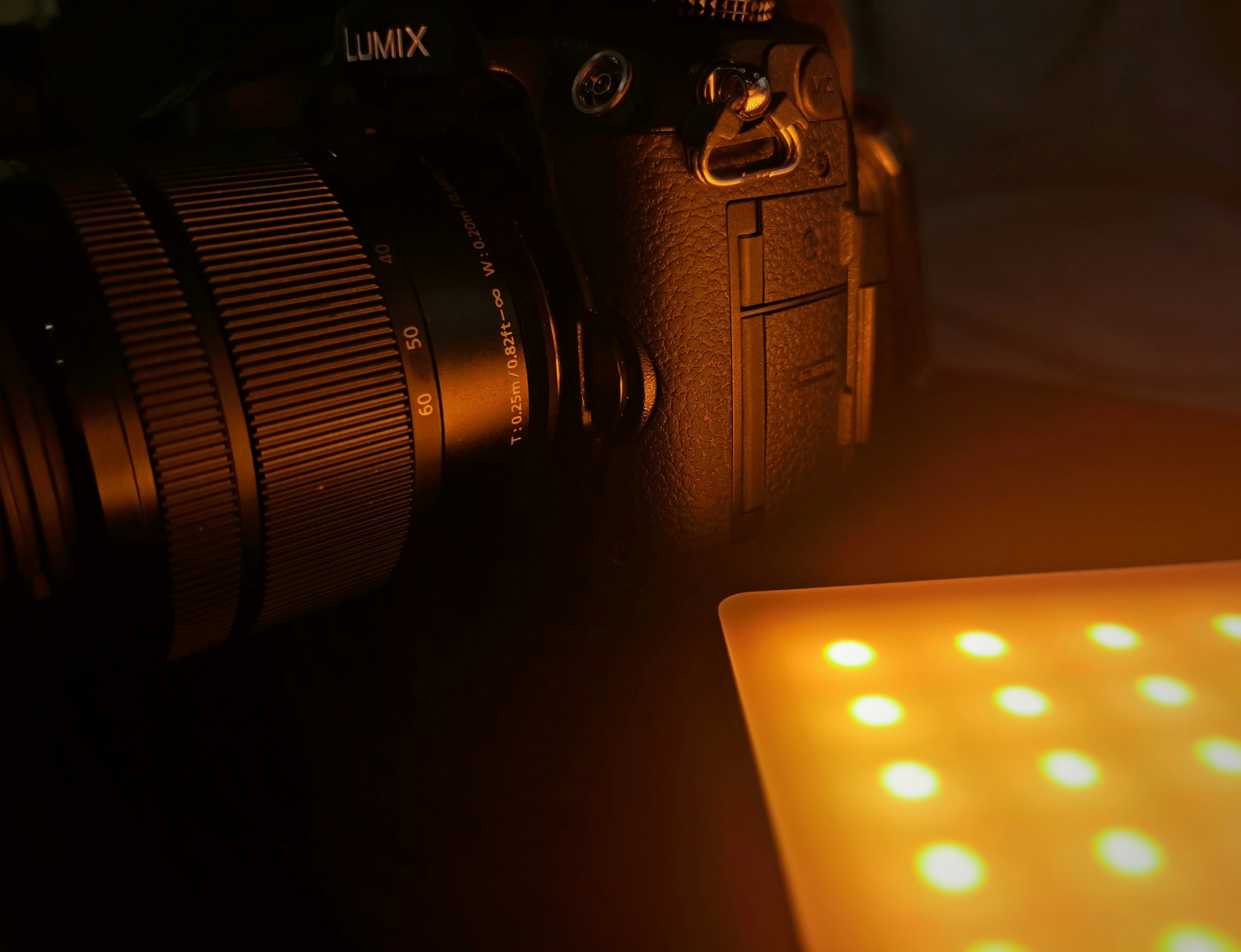 Dim Studio Moment: A Lumix Team’s Lens Paused Over Warm LED Light
