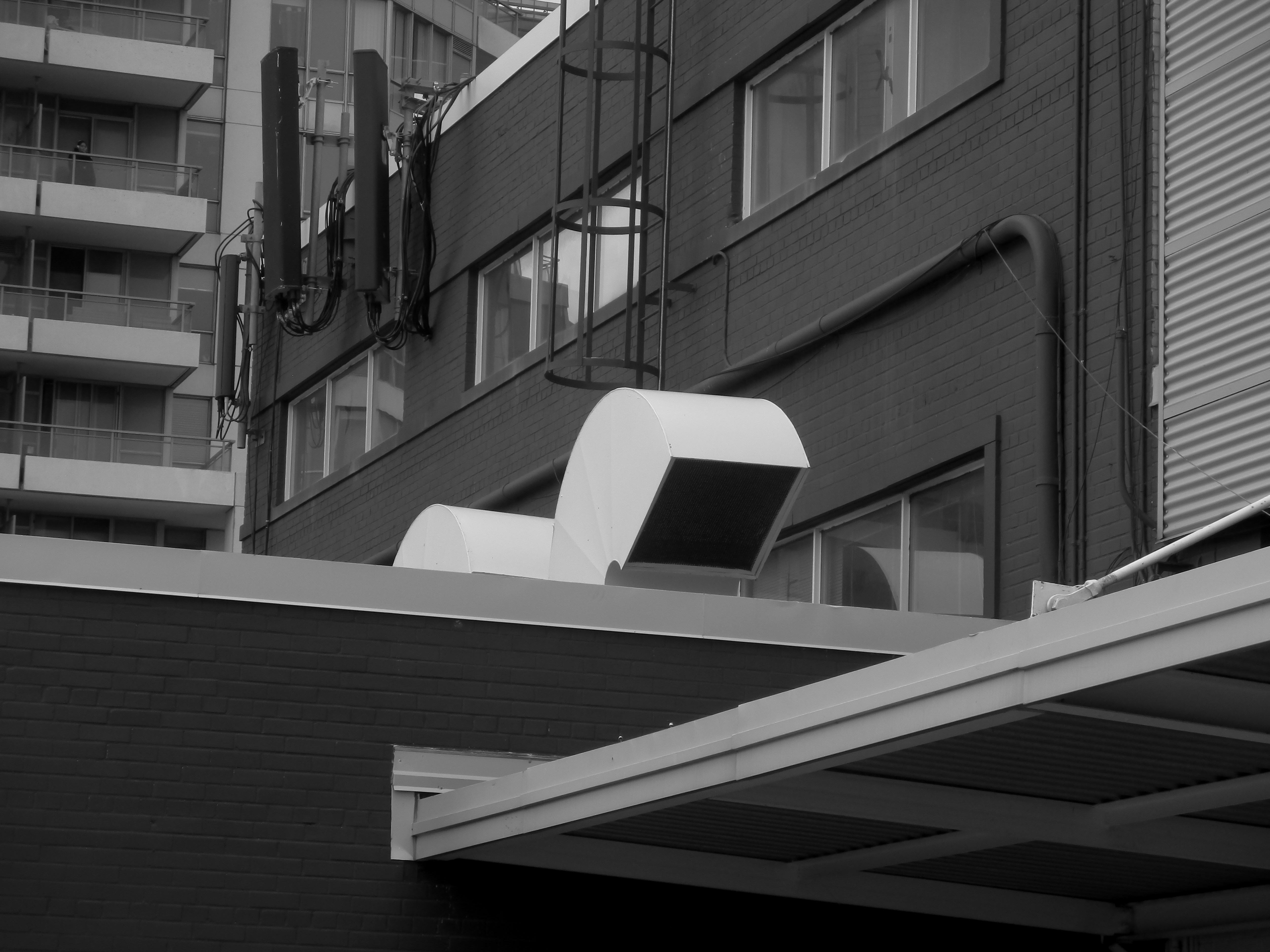 Urban Geometry: A Slice of Rooftop Machinery Against Concrete Horizons