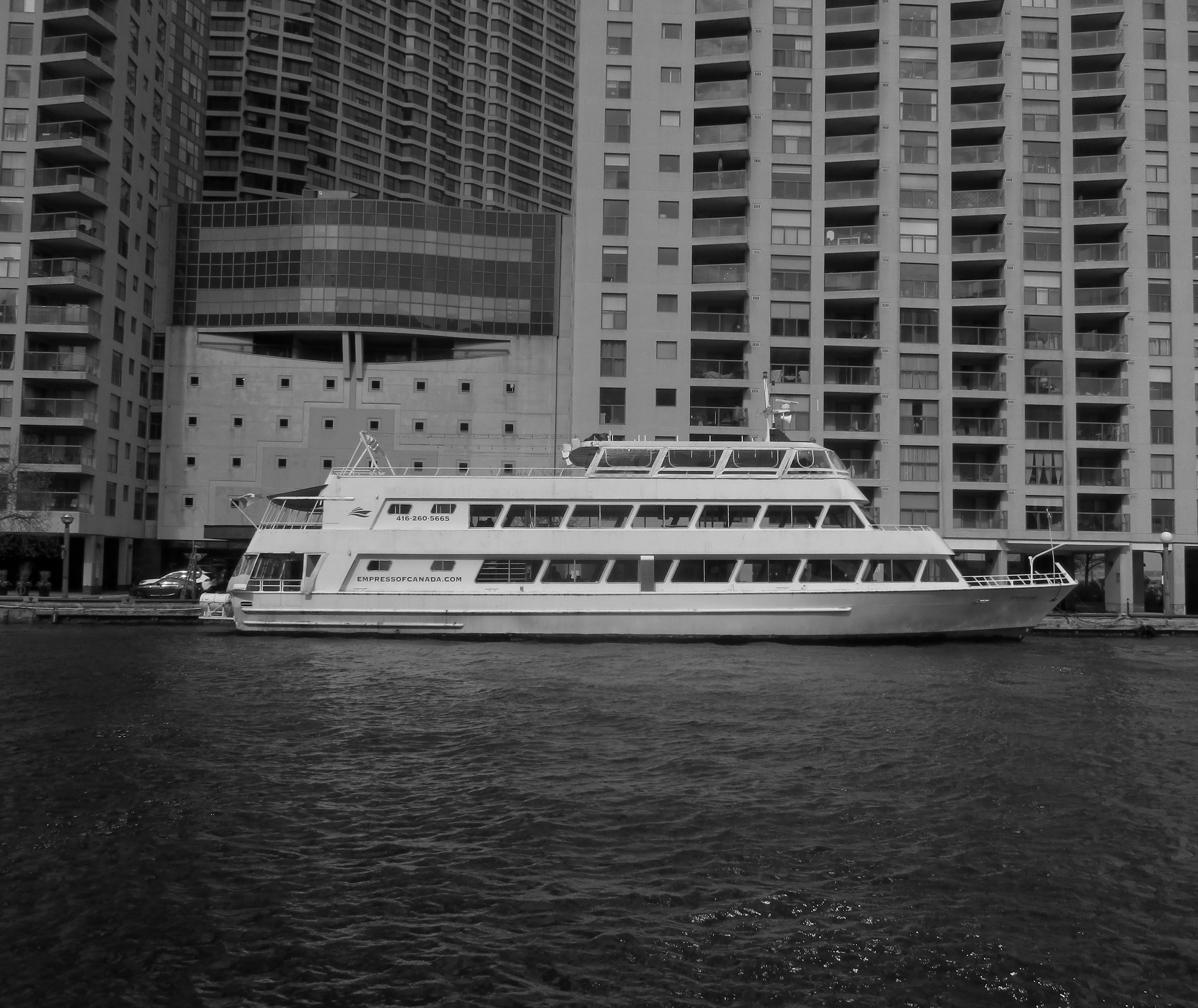 Docked in monochrome: a river cruise beside glass towers