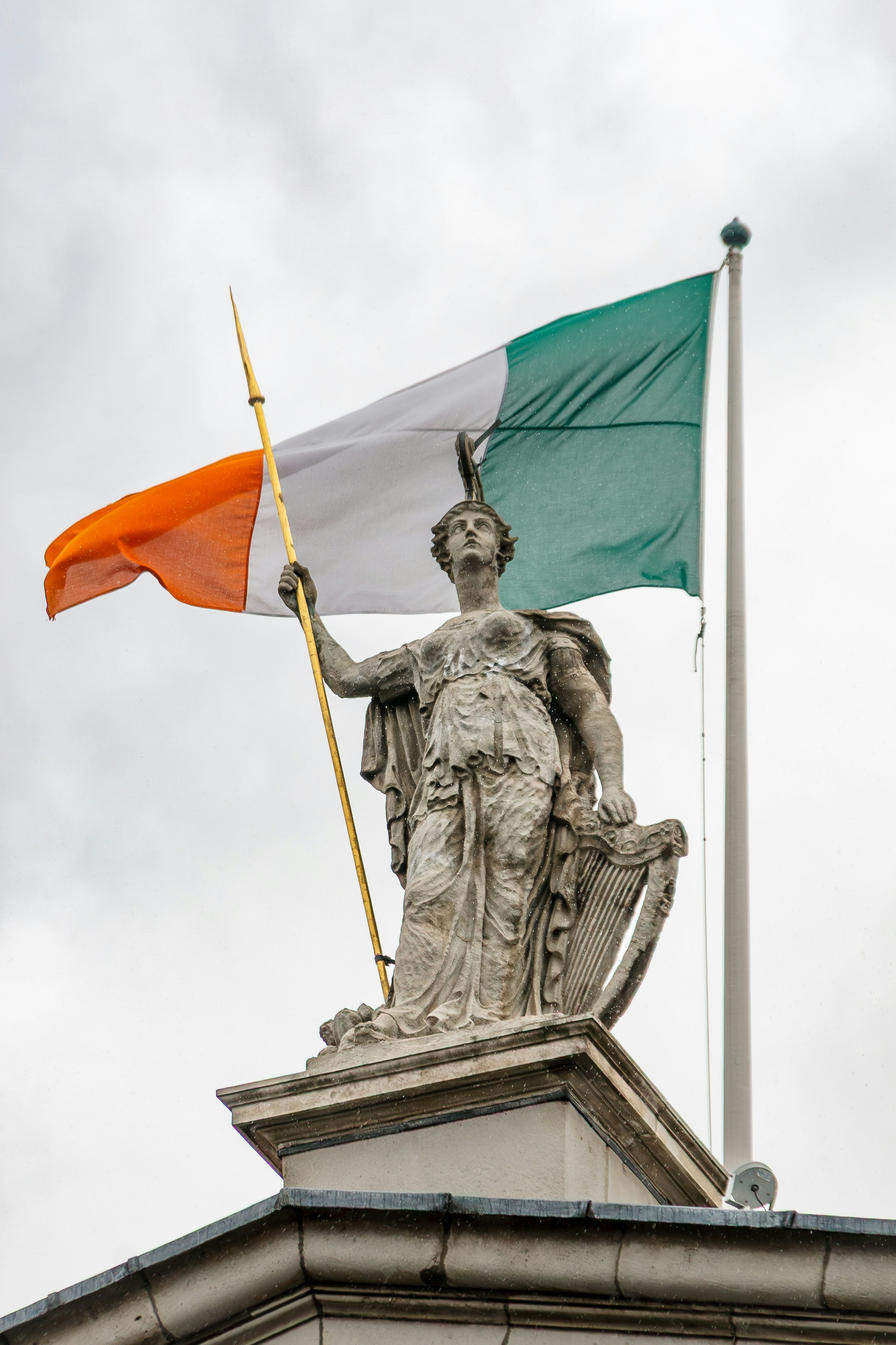 Flag and statue: a solemn ascent above the city