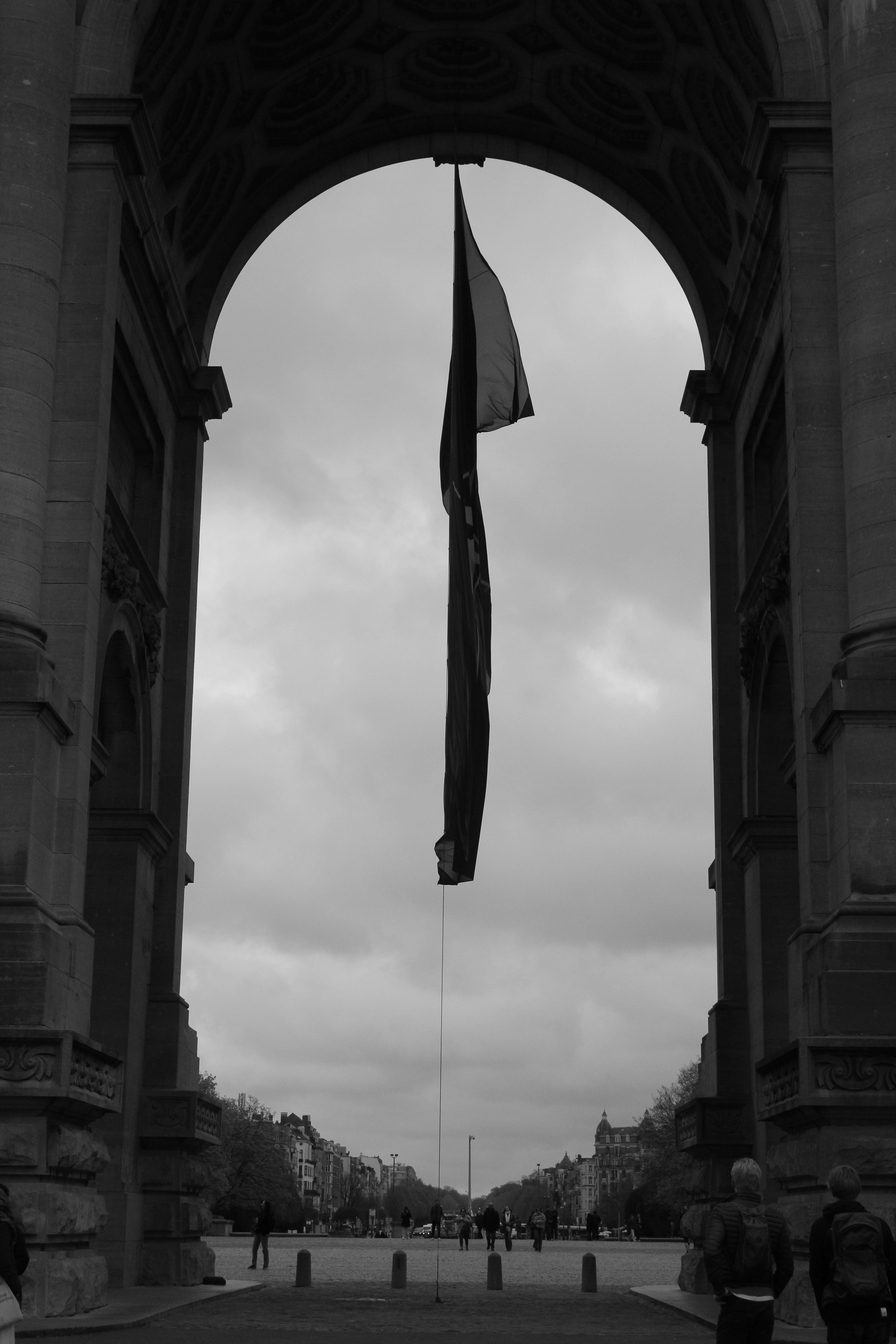 A Monumental Dark Arch: Flag Centered under an Overcast Arc