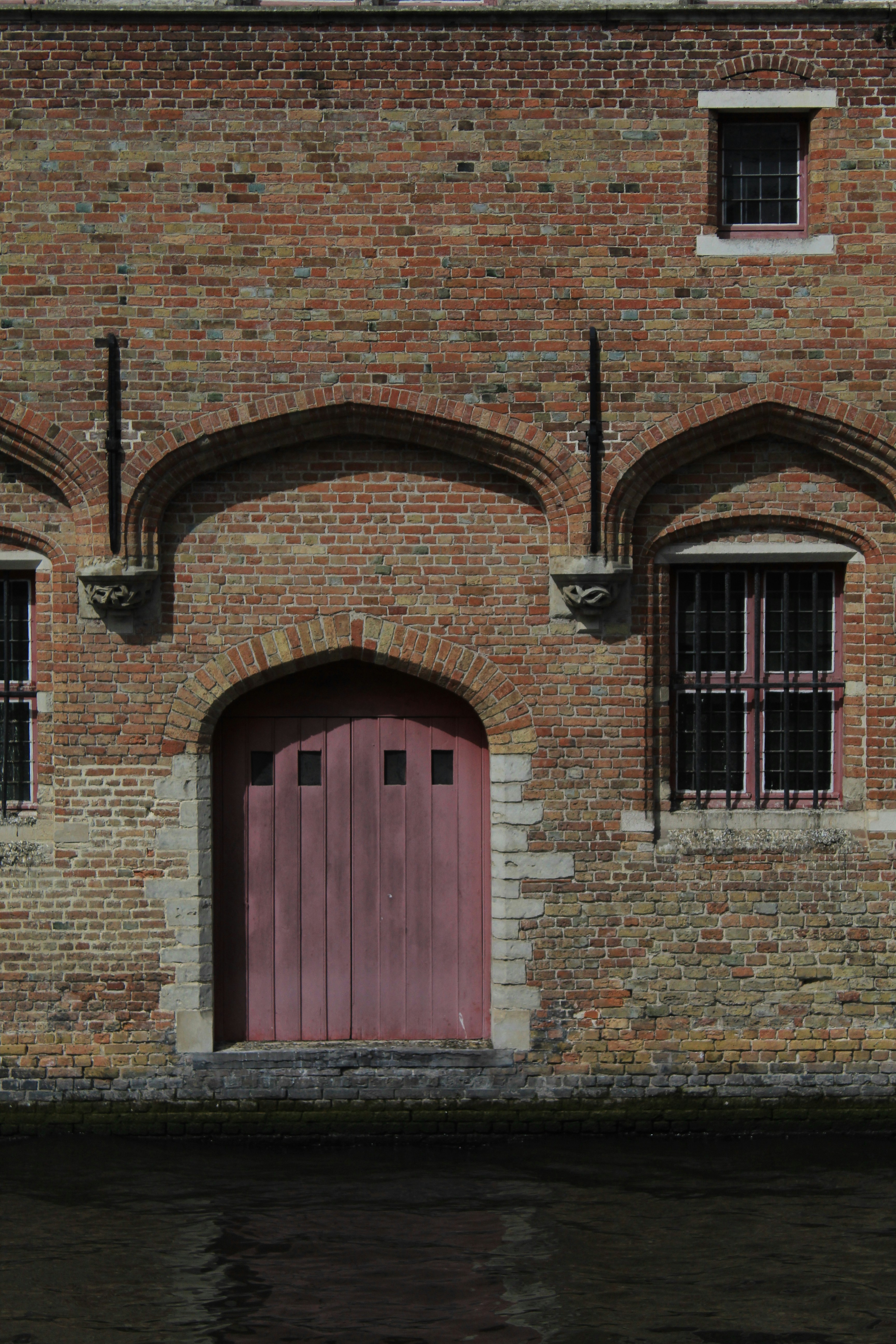 Brick Courtyard Facade with Arched doorway and Moorings