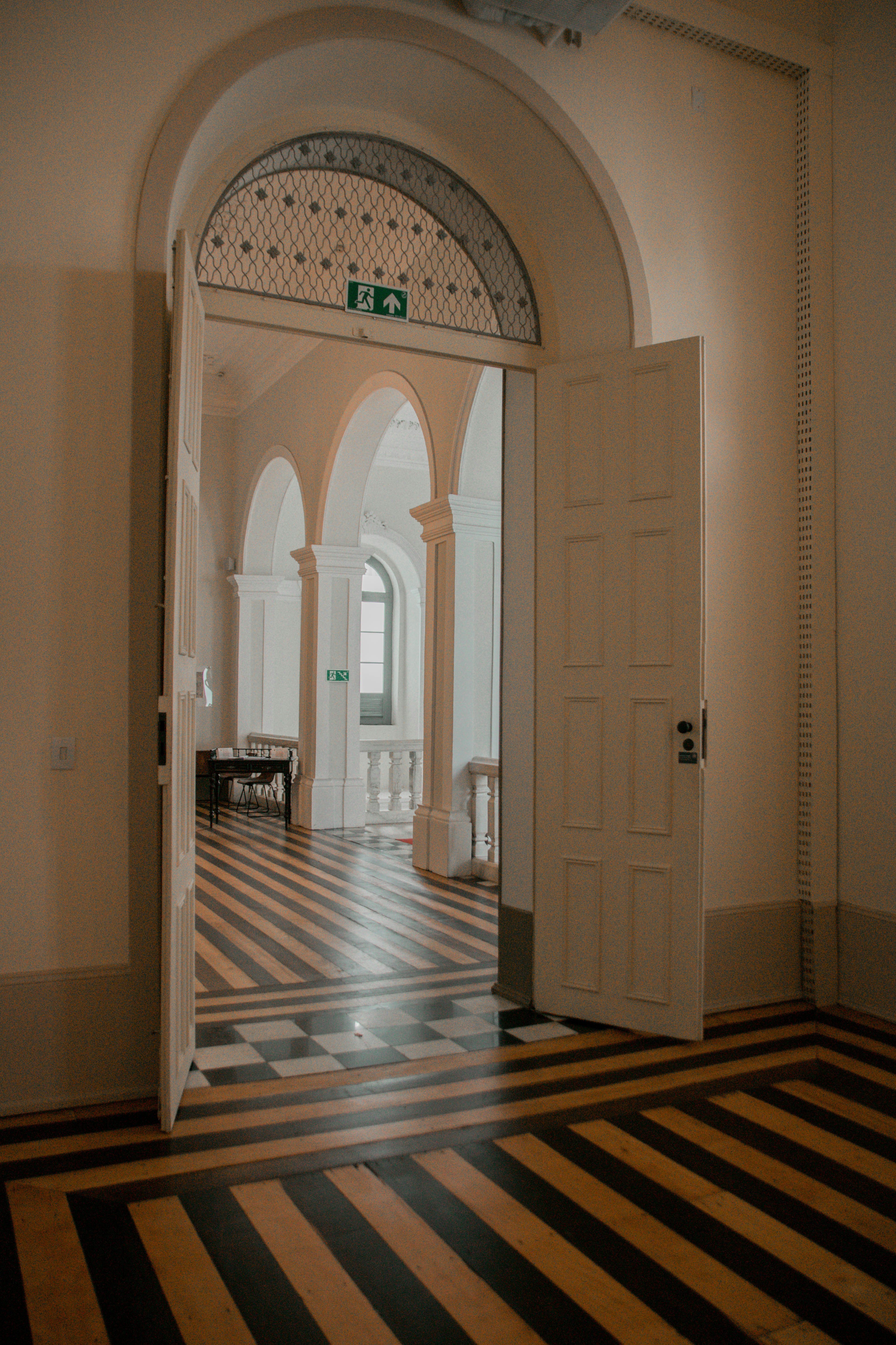 Open Doors into a Sunlit Corridor of Arches