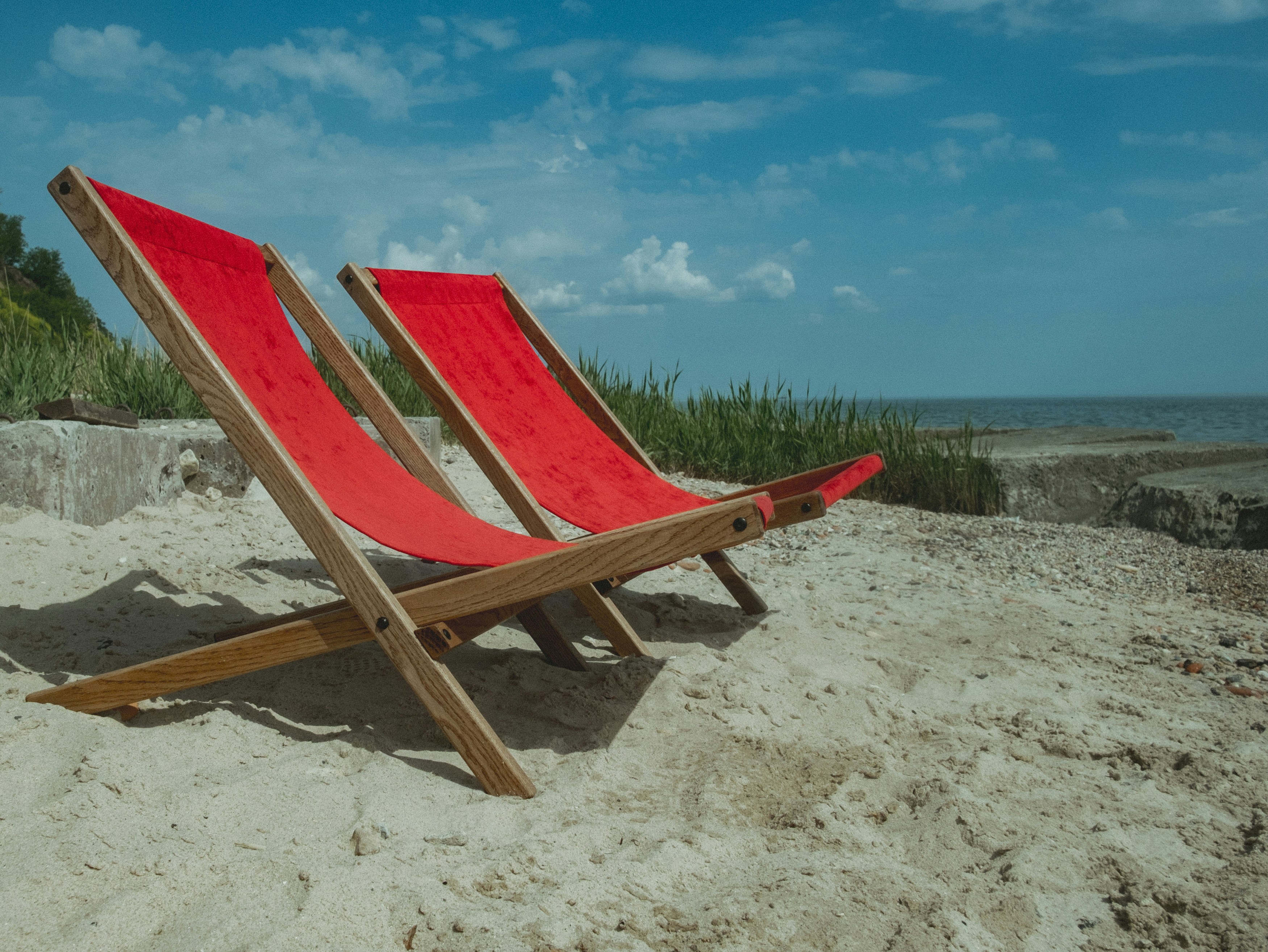 Red Beach Chairs Anchored by Sand and Sea