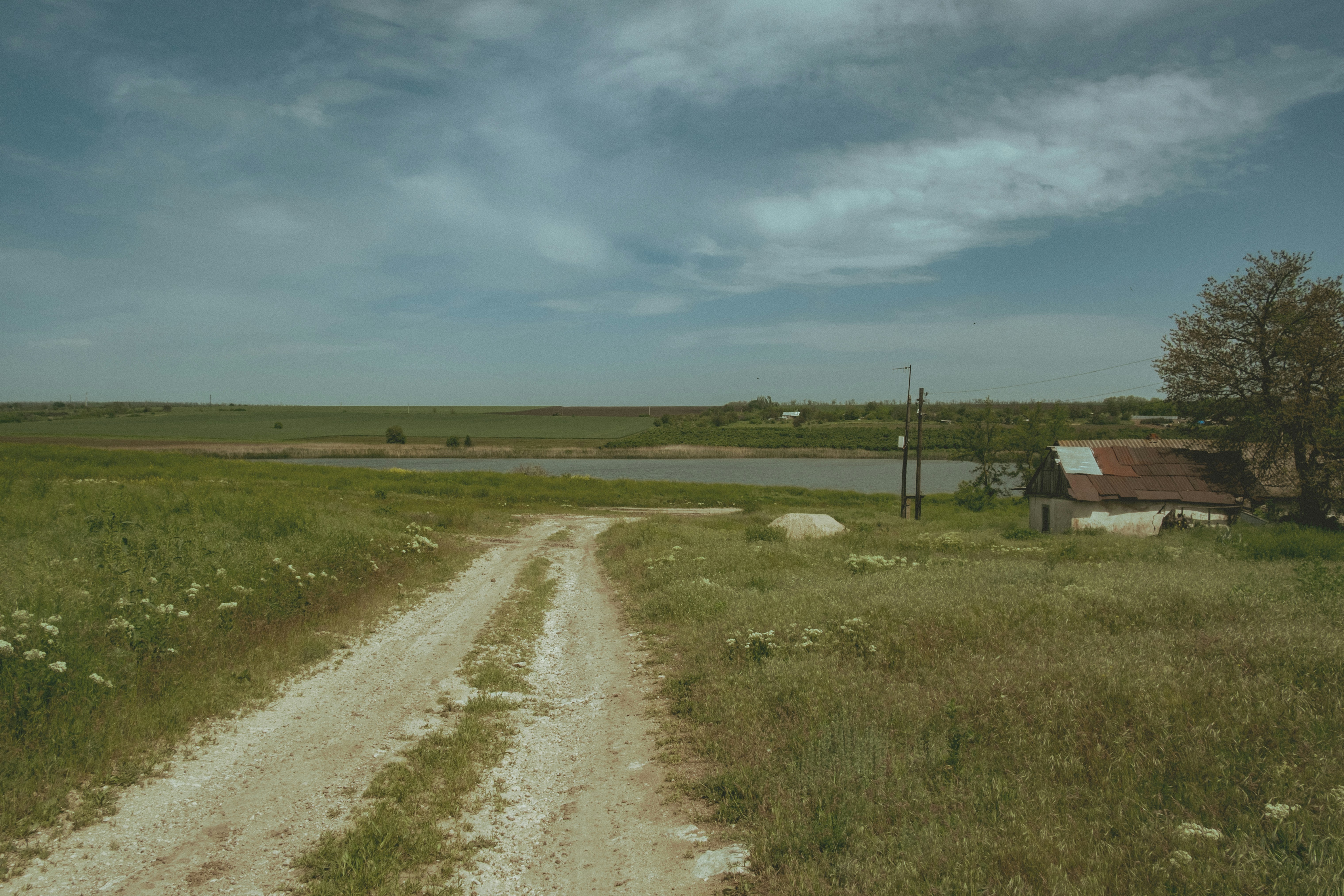 Dusty Rural Path to a Quiet Farm by the River
