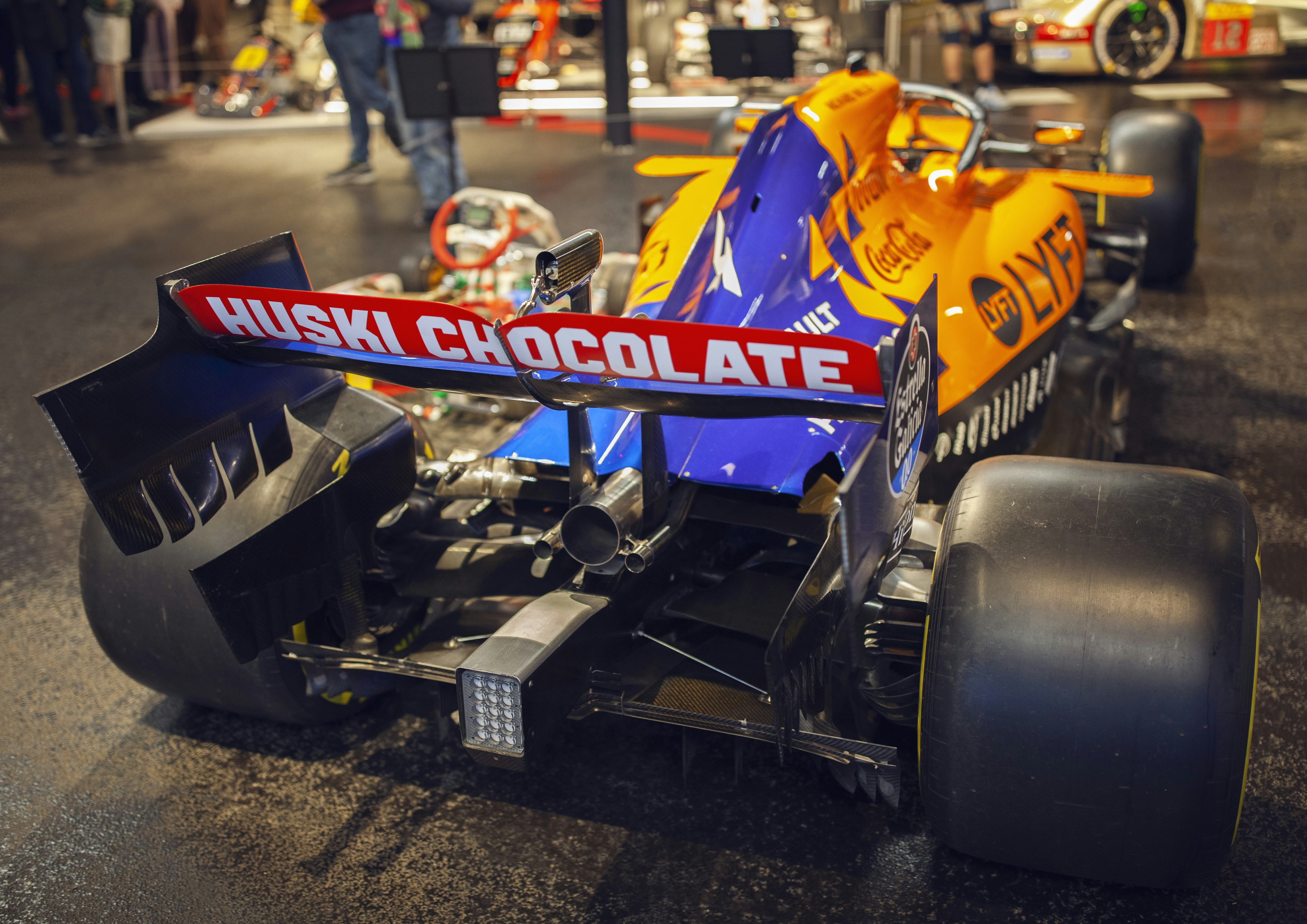 Rear View of a Formula Car in a Showroom Highlighting the Husky Chocolates Livery