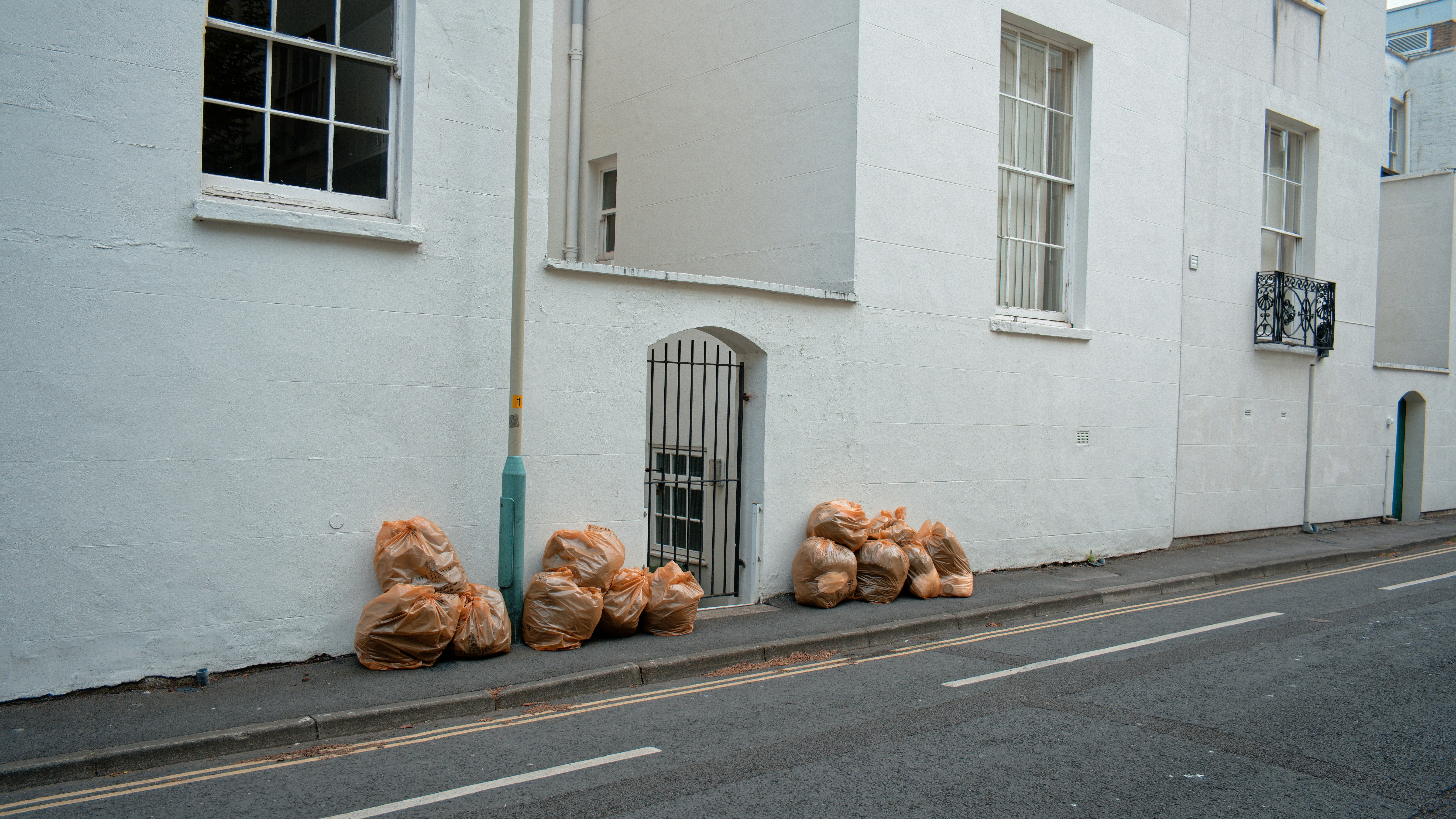 Crates of Garbage at a Quiet White-walled Street Corner