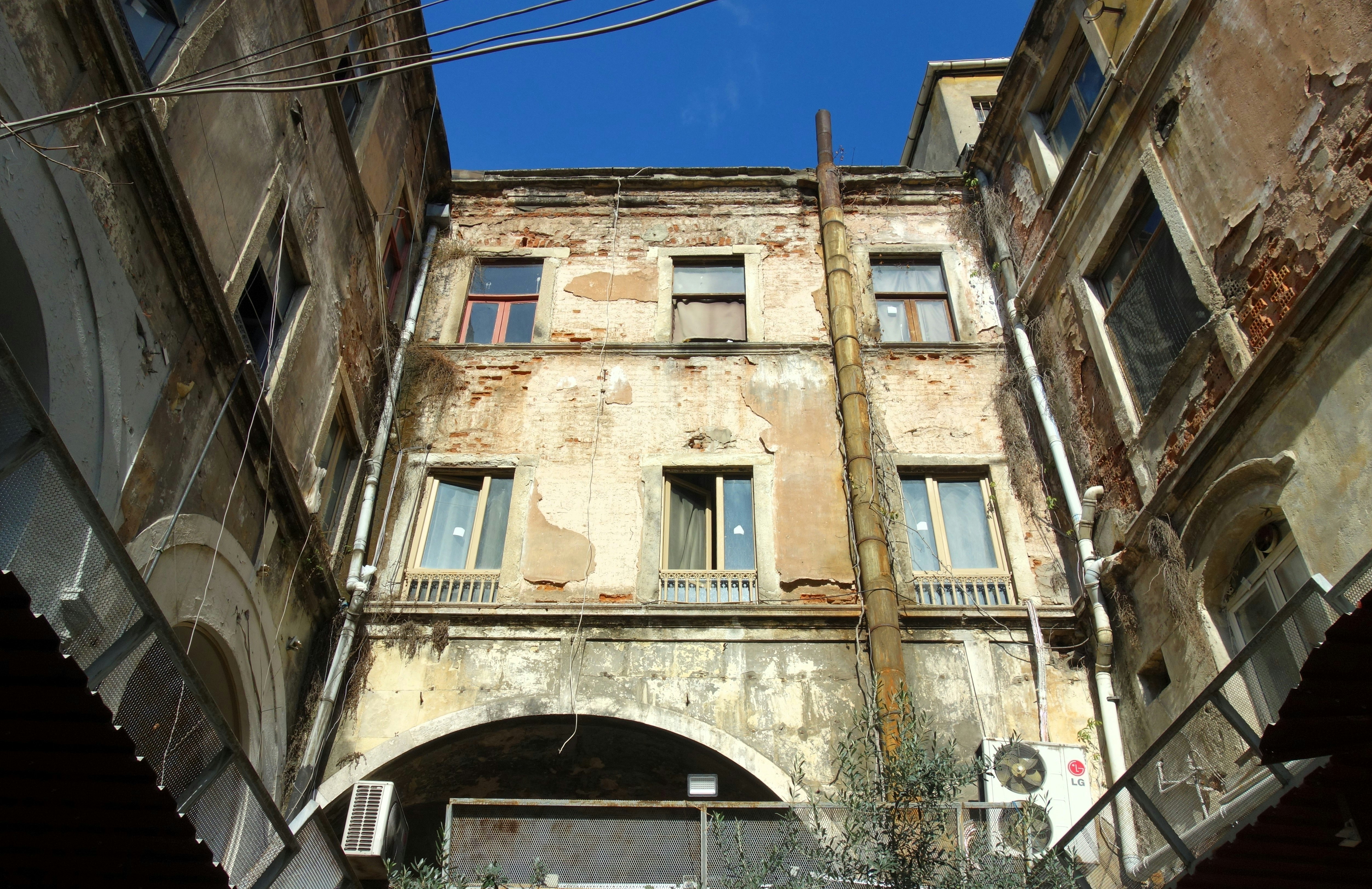Weathered Facade: An Archway Frame into Aged Townhouses