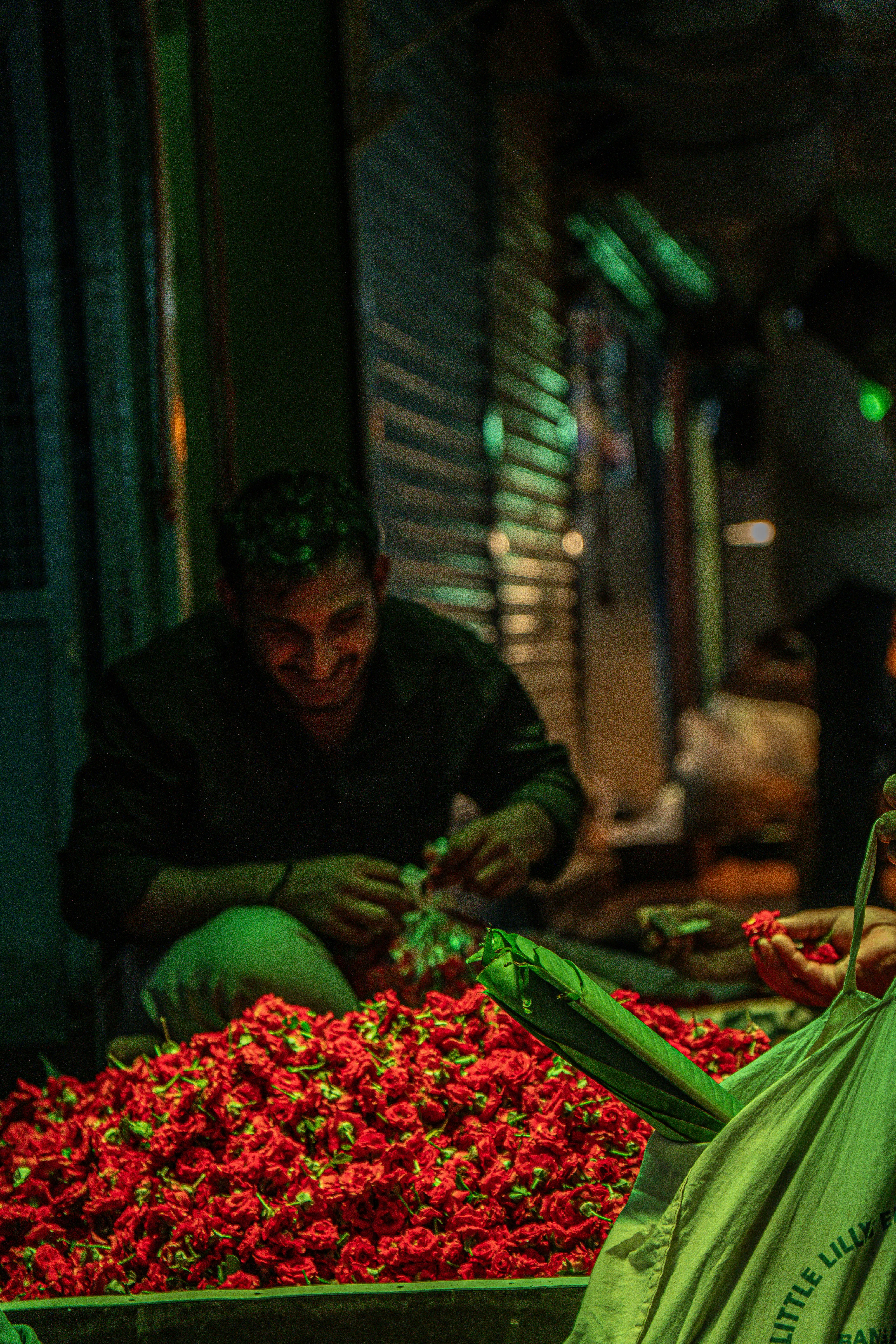 Green glow over a flower vendor at a dim street market