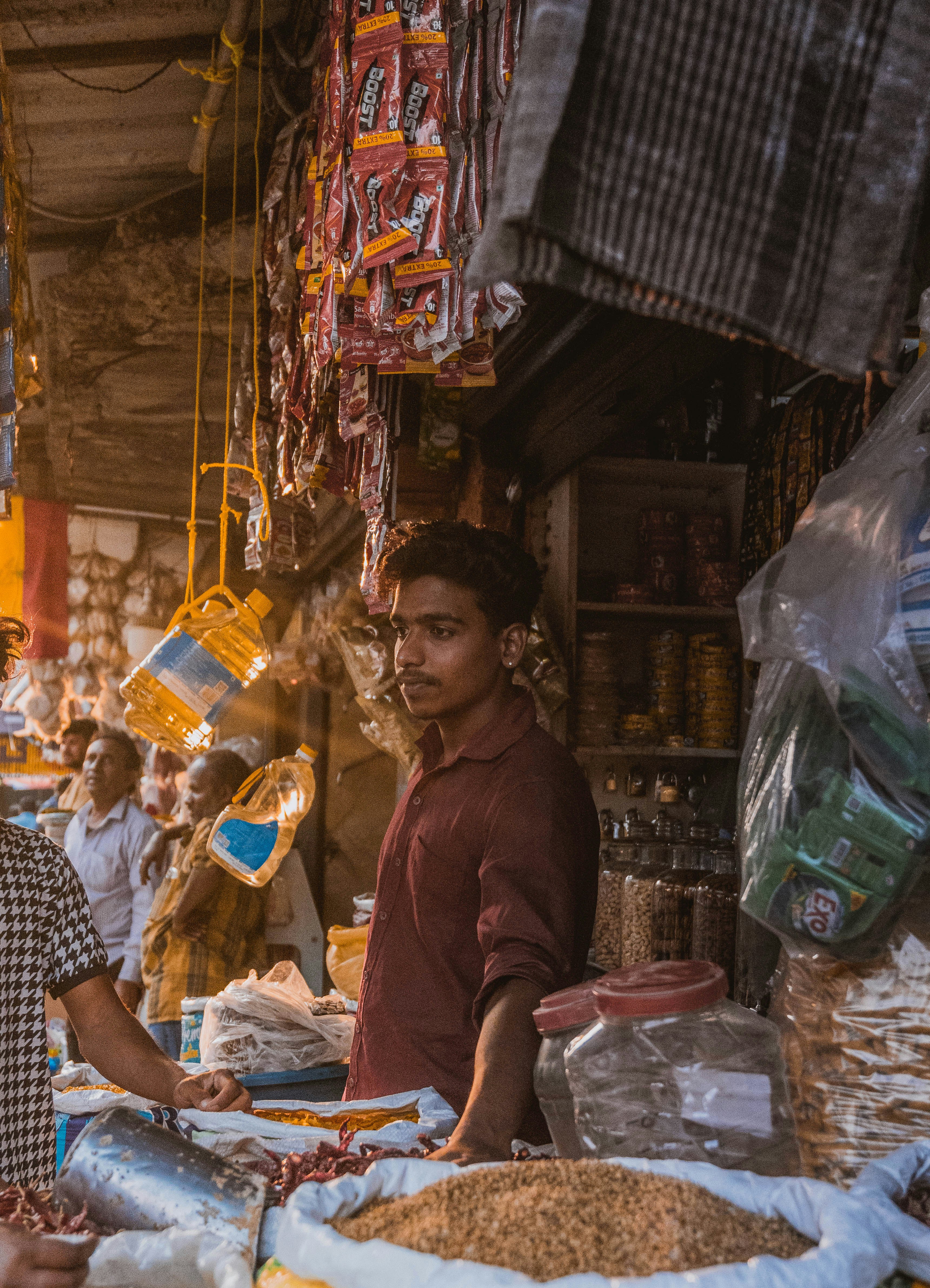 Market Vendor with Suspended Packaging Amid Busy Street Scene