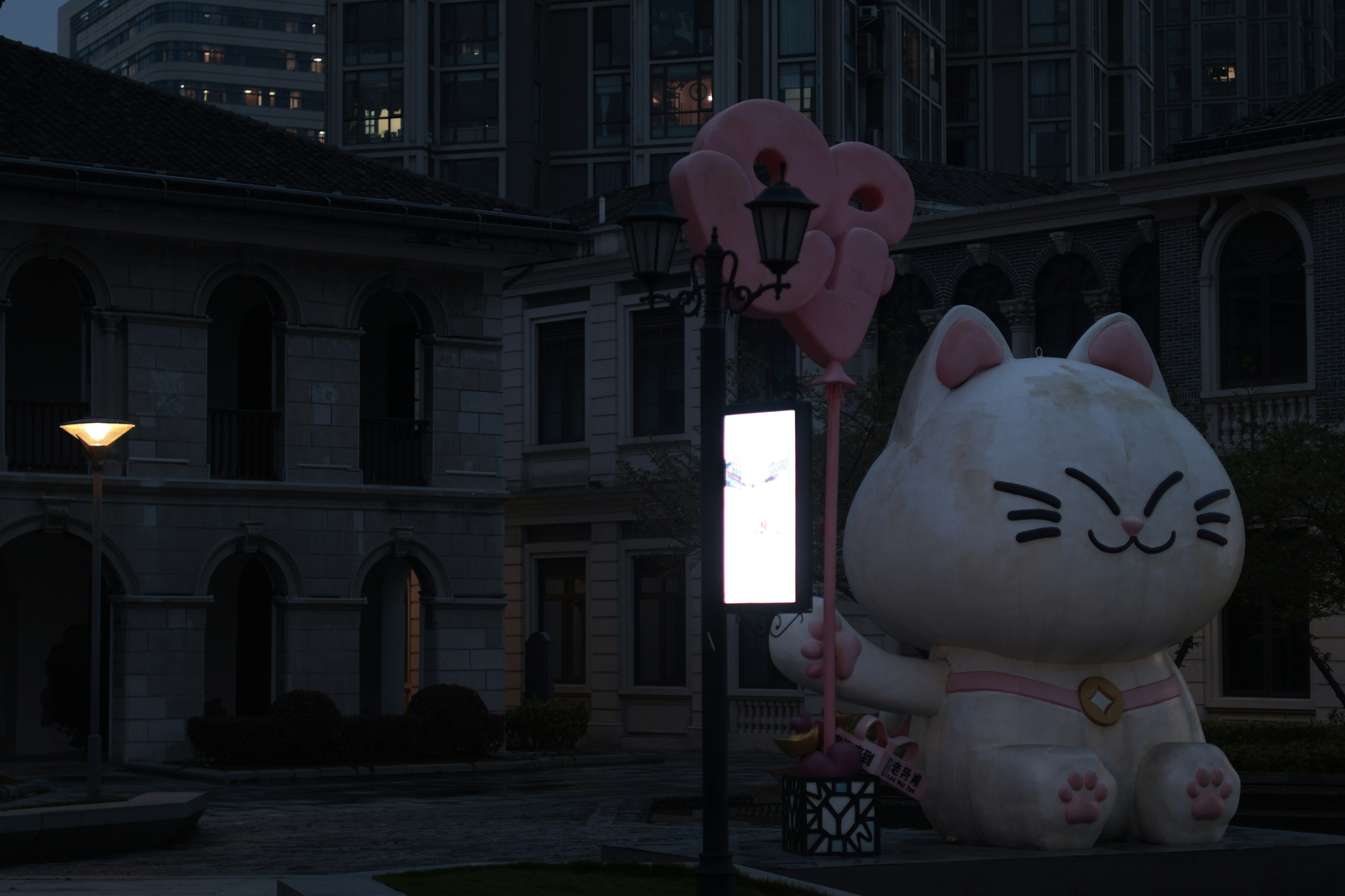 Nighttime Neon Cat: A Quiet Plaza with a Laughing Statue