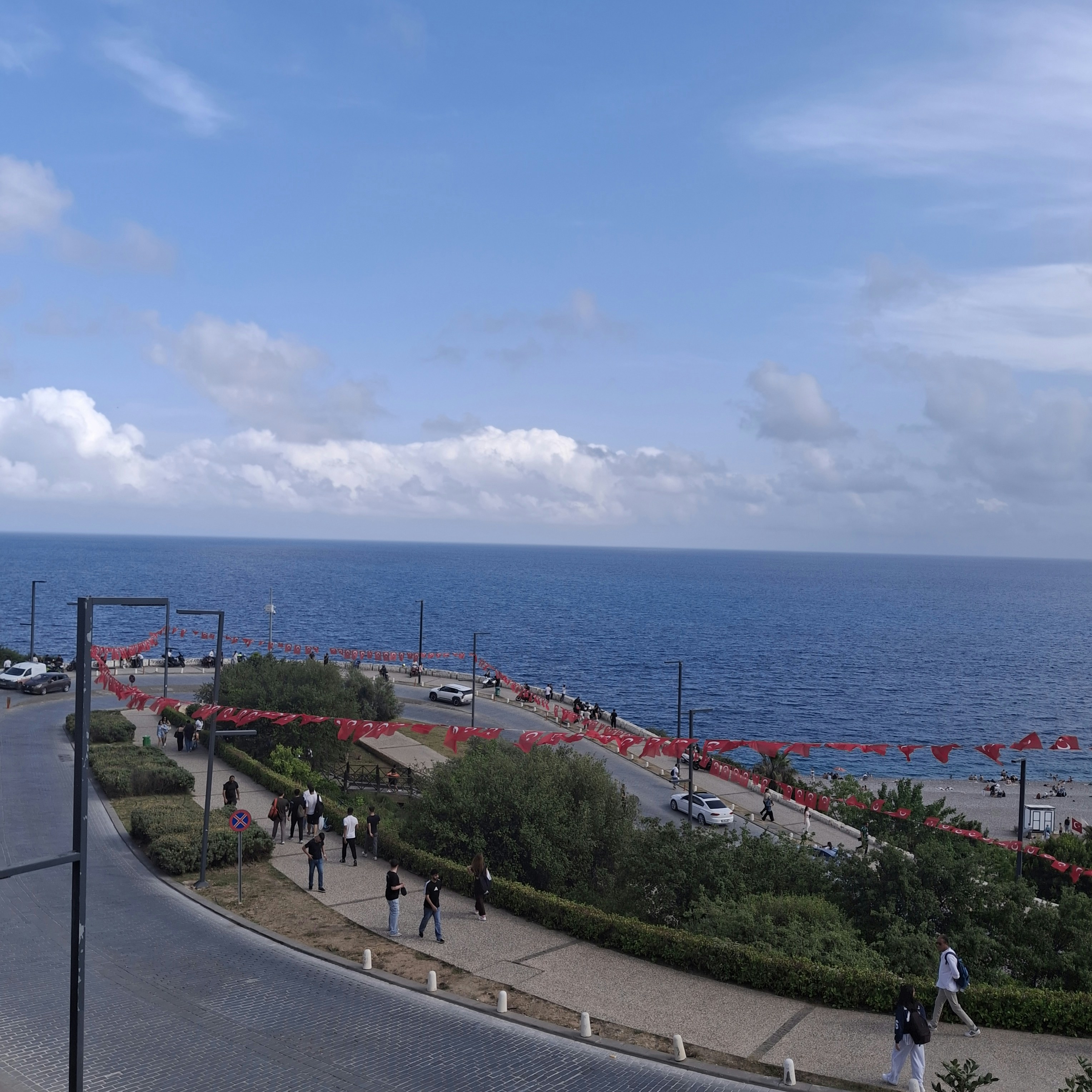 Coastal Promenade Framed by Red Flags and Sea Breeze