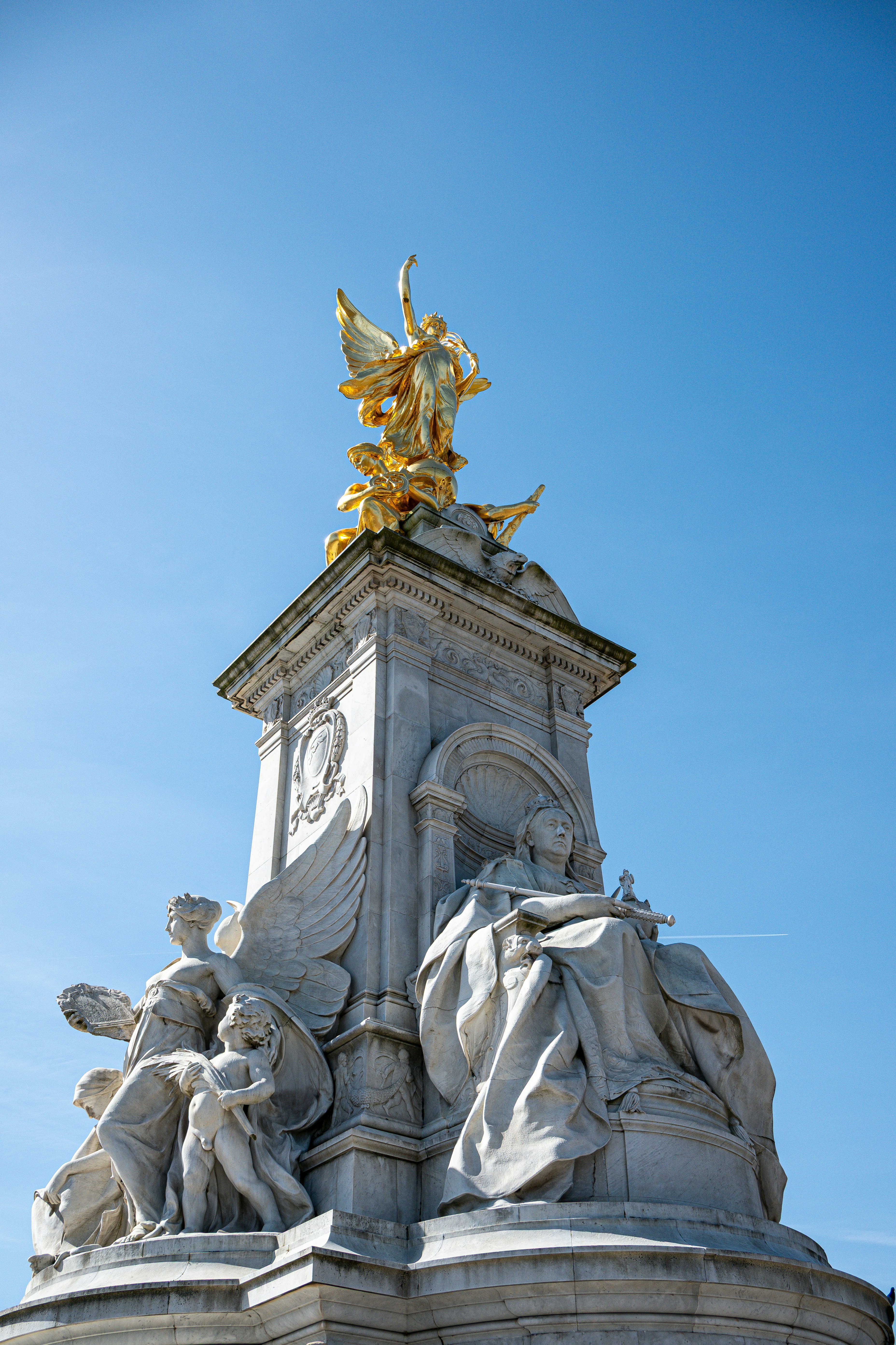 Golden Statue Crowned by Azure Sky atop Marble Monument
