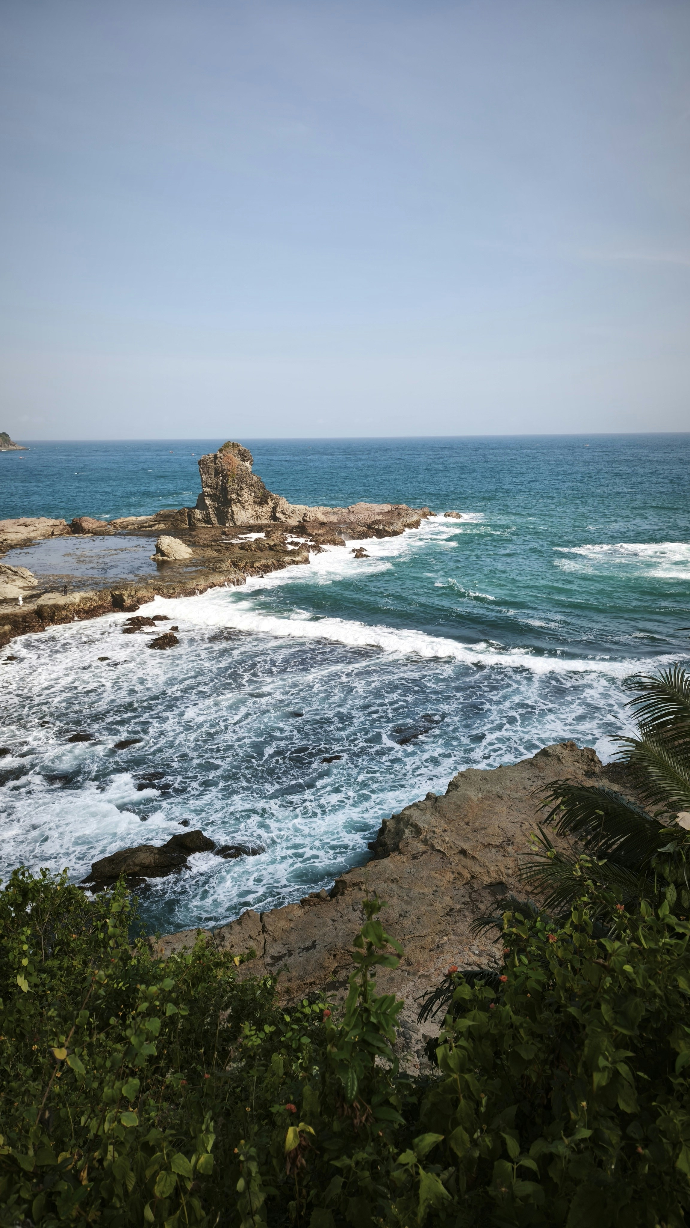 Rugged coastline with sunlit sea over rocky promontory