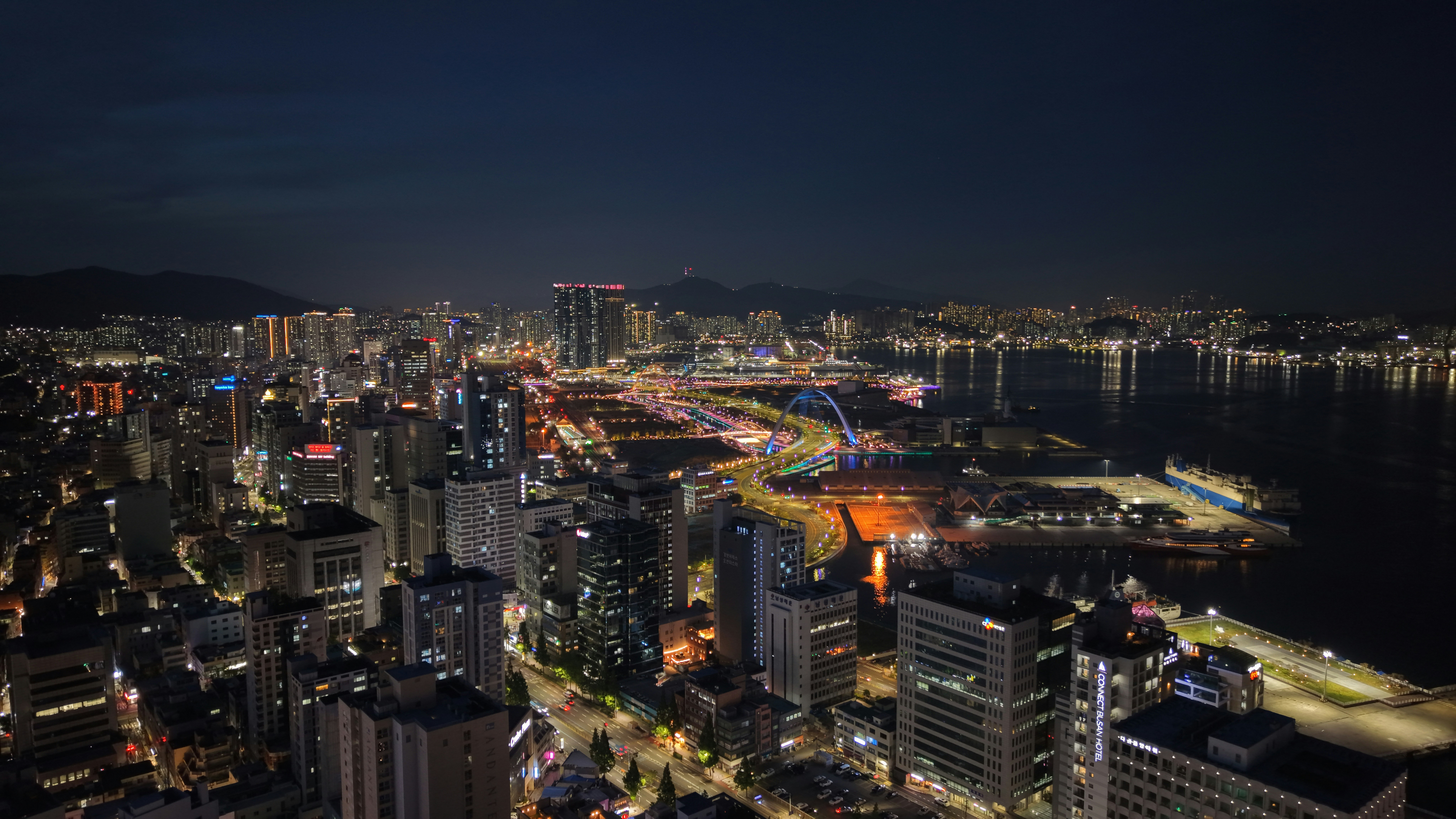 Nightflight over a Neon Coast: Aerial Cityscape at Dusk
