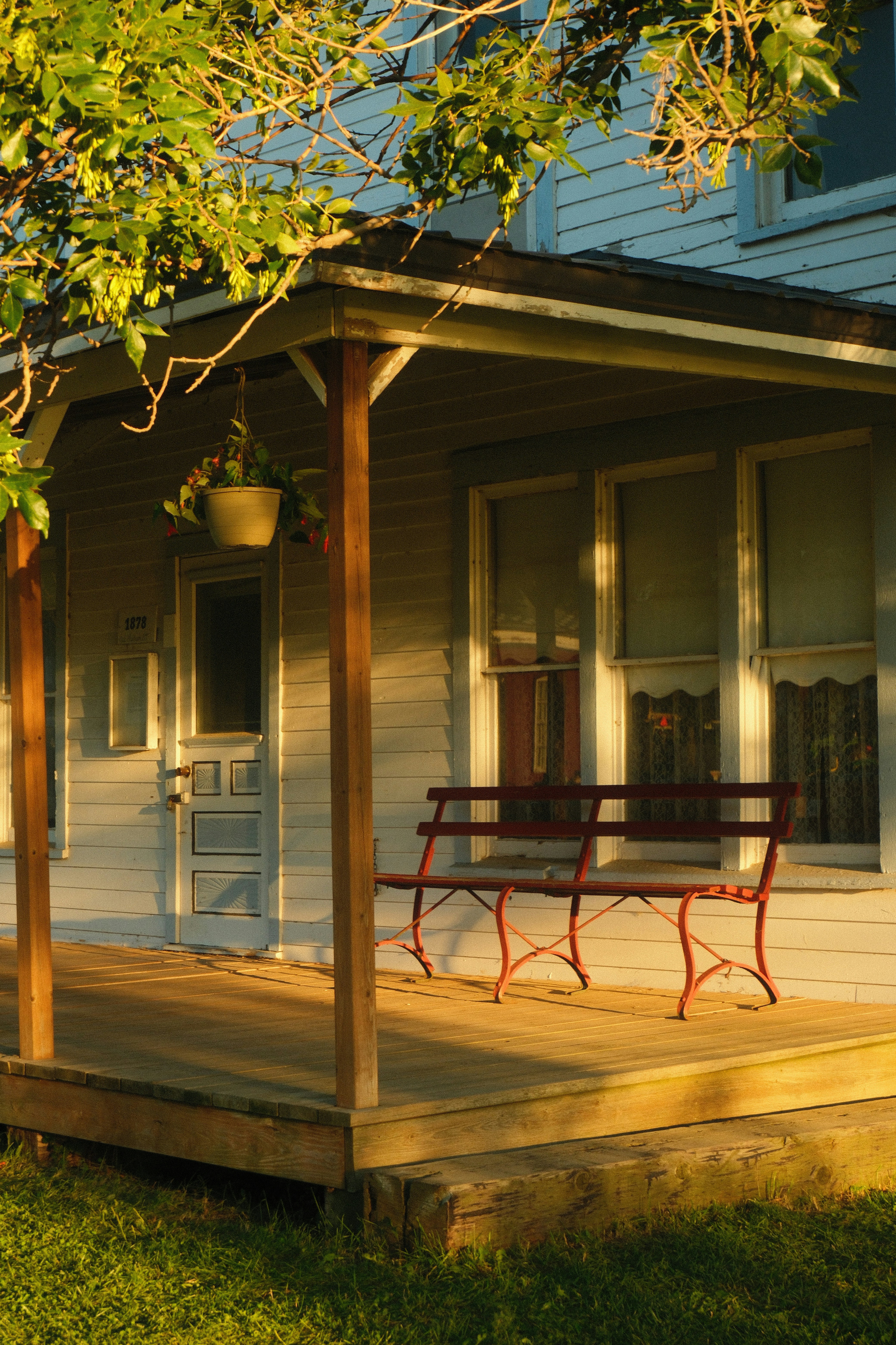 Sunlit Porch Portrait: A Quiet Front Porch with Red Bench