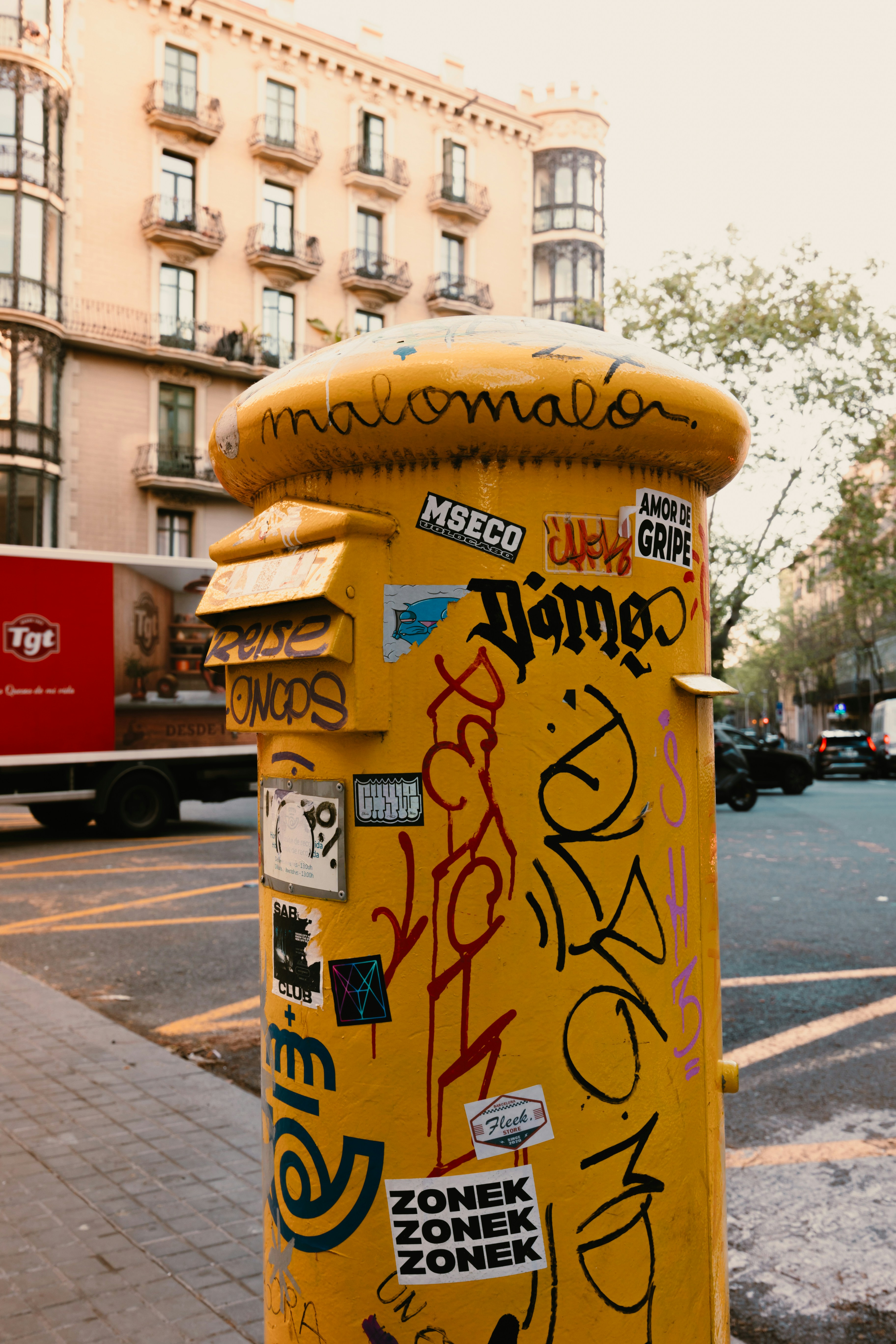 Yellow Street Mailbox Adorned with Graffiti in a City Corner