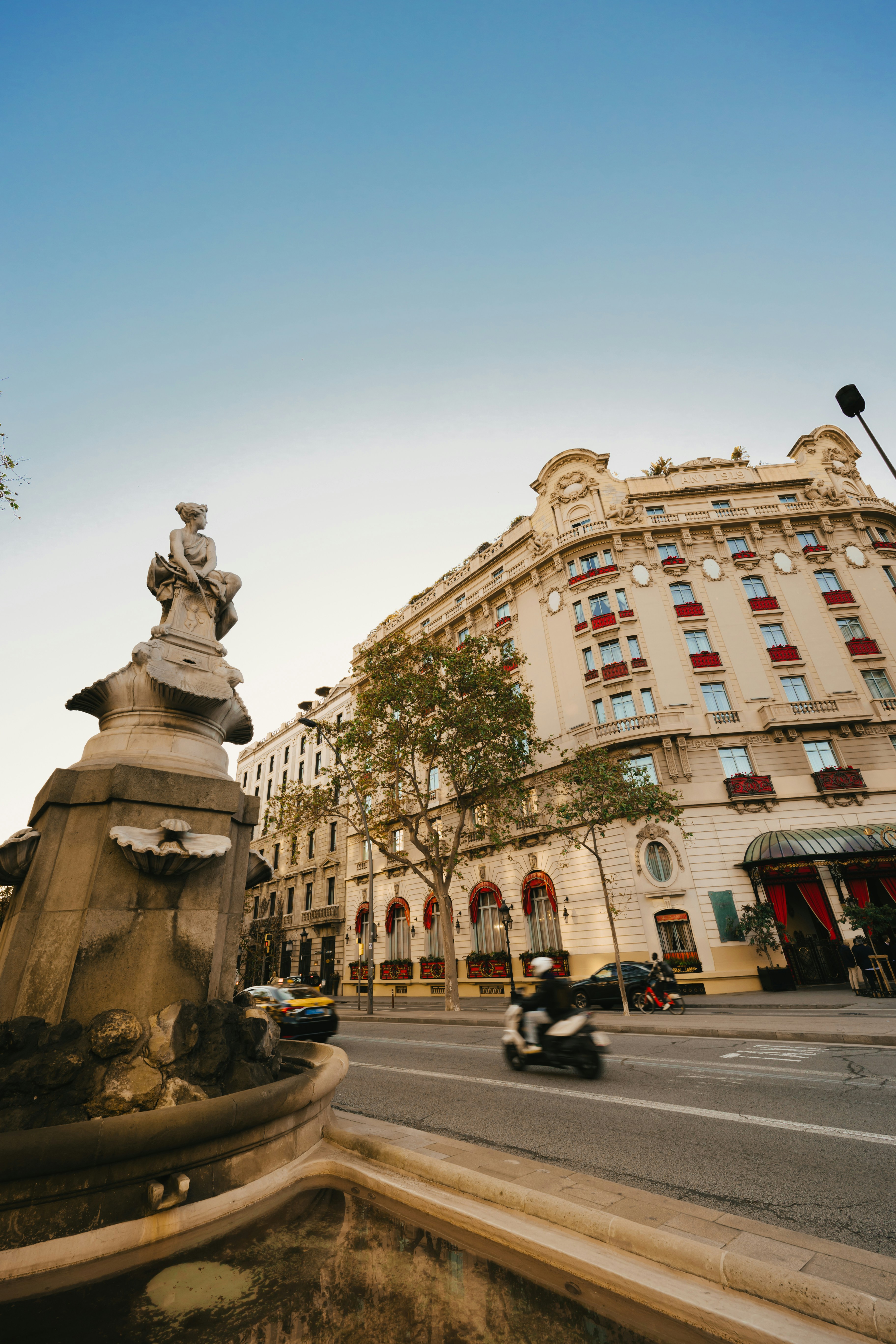 Urban Marble: Statue, Fountain, and Façade Under a Clear Sky