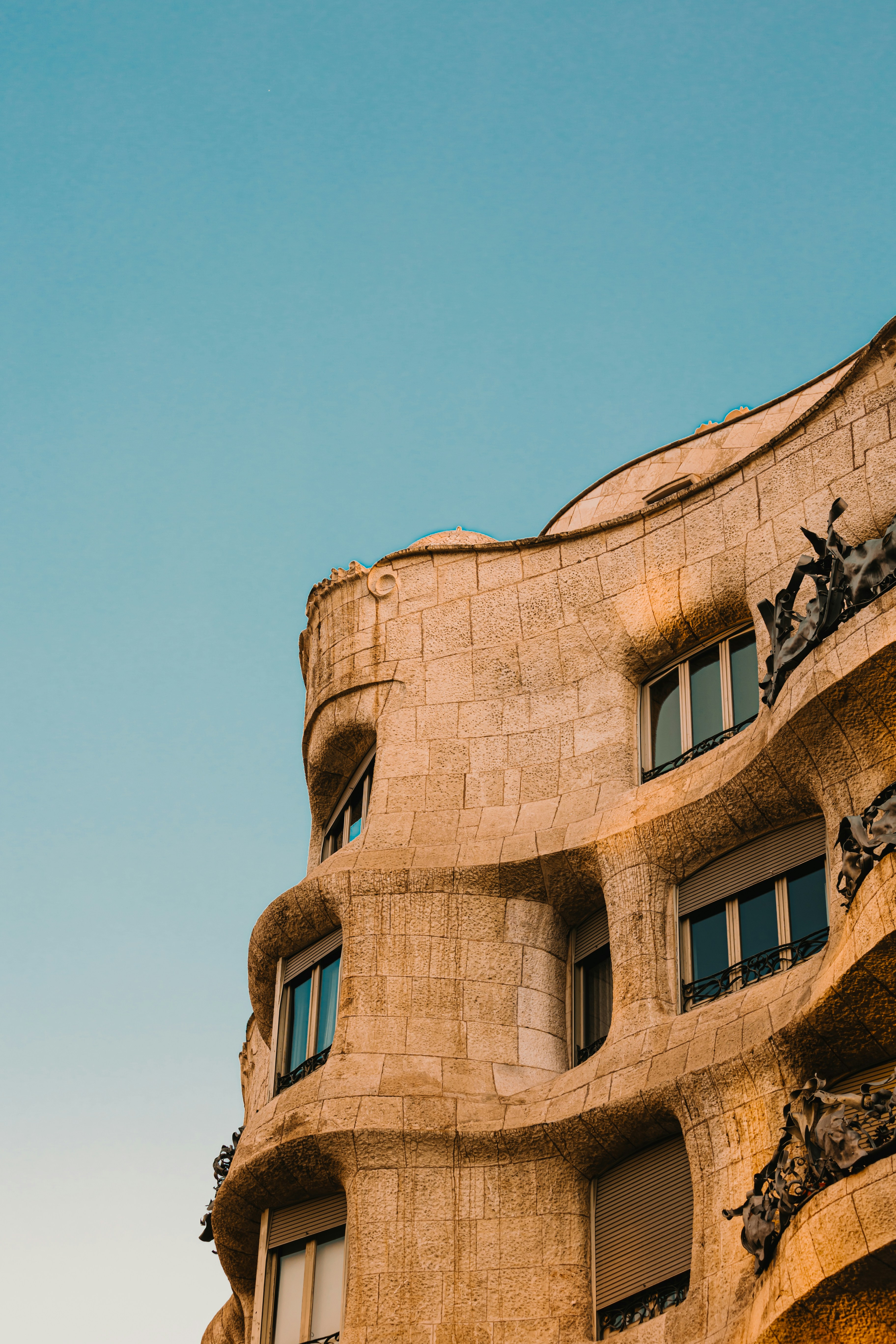 Curved Stone Facade Reaching Toward a Clear Sky