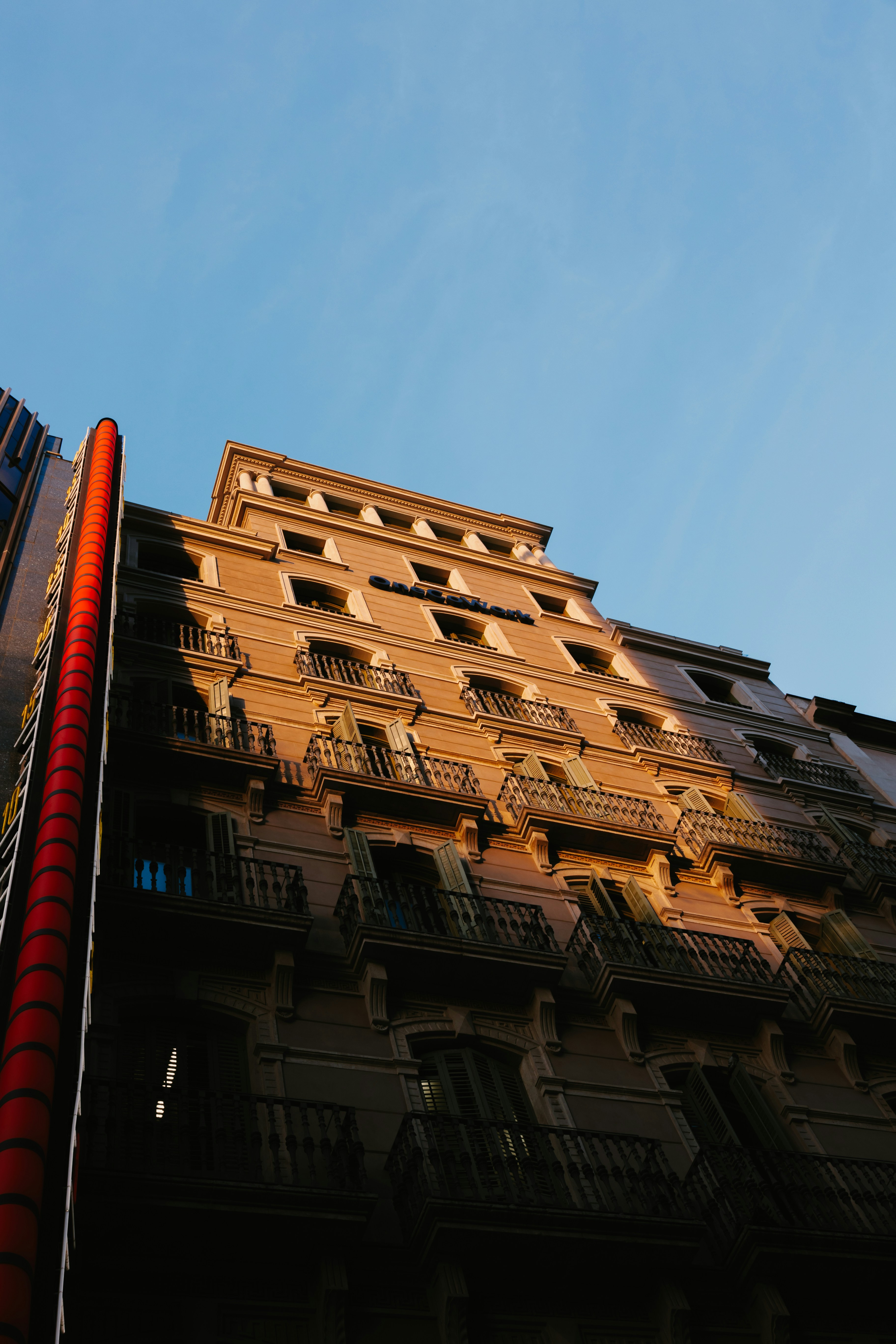 Sunlit Facade Ascending into a Clear Sky