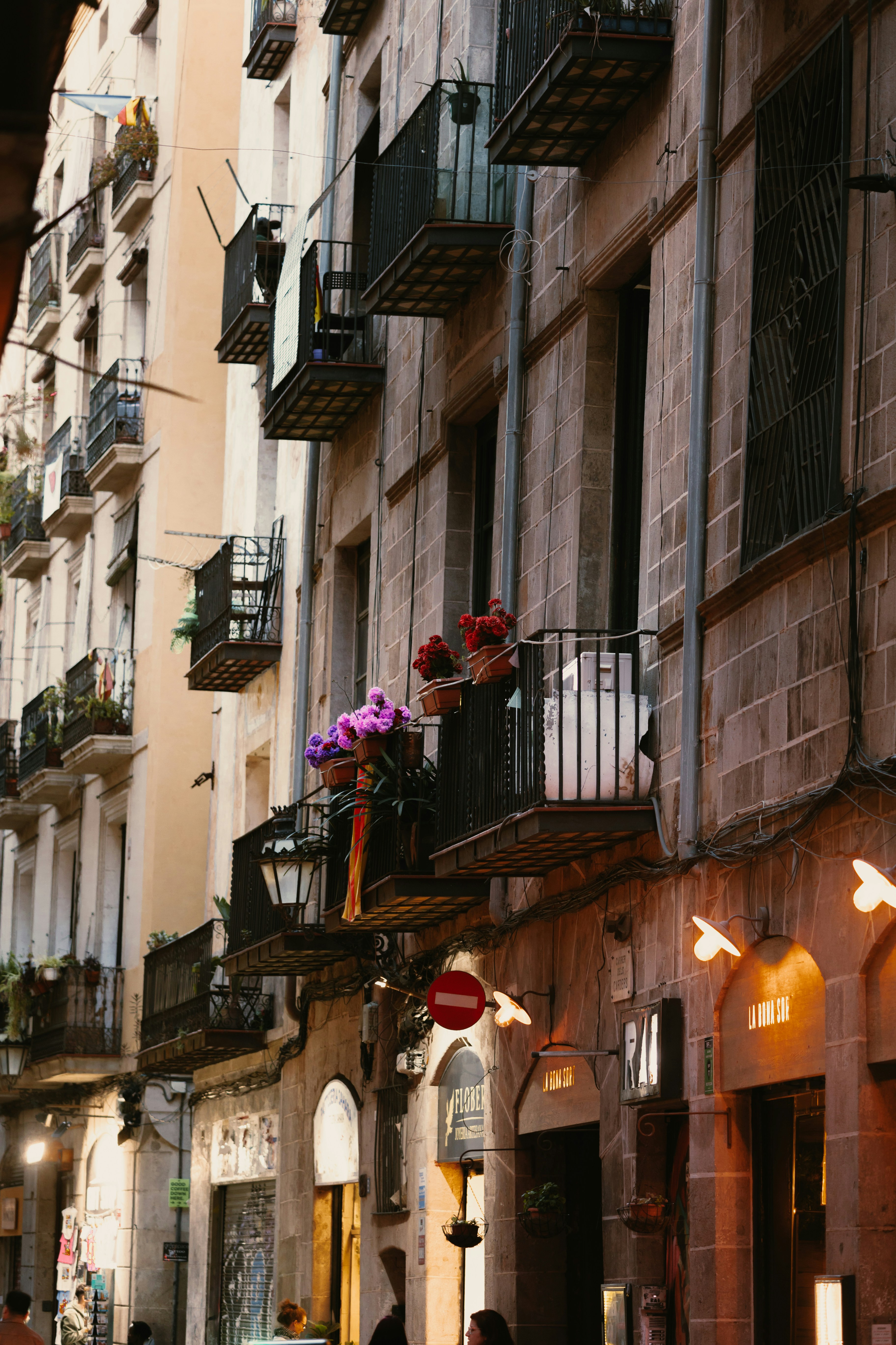 Balconies Over a Narrow Calle: Warm Light and Flowered Facades