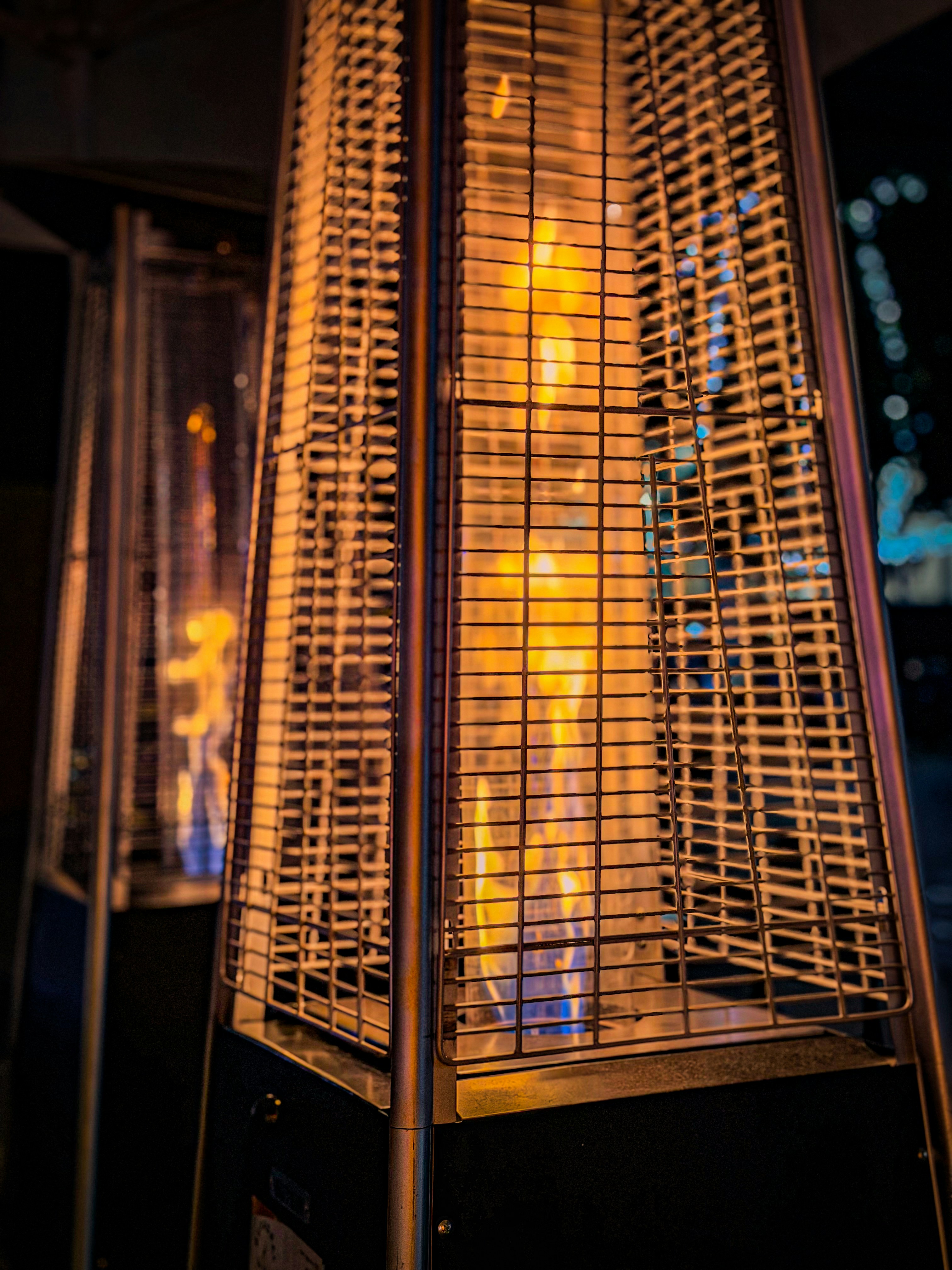 Flames Behind Gridded Panel: Night Heaters in Neon Glow