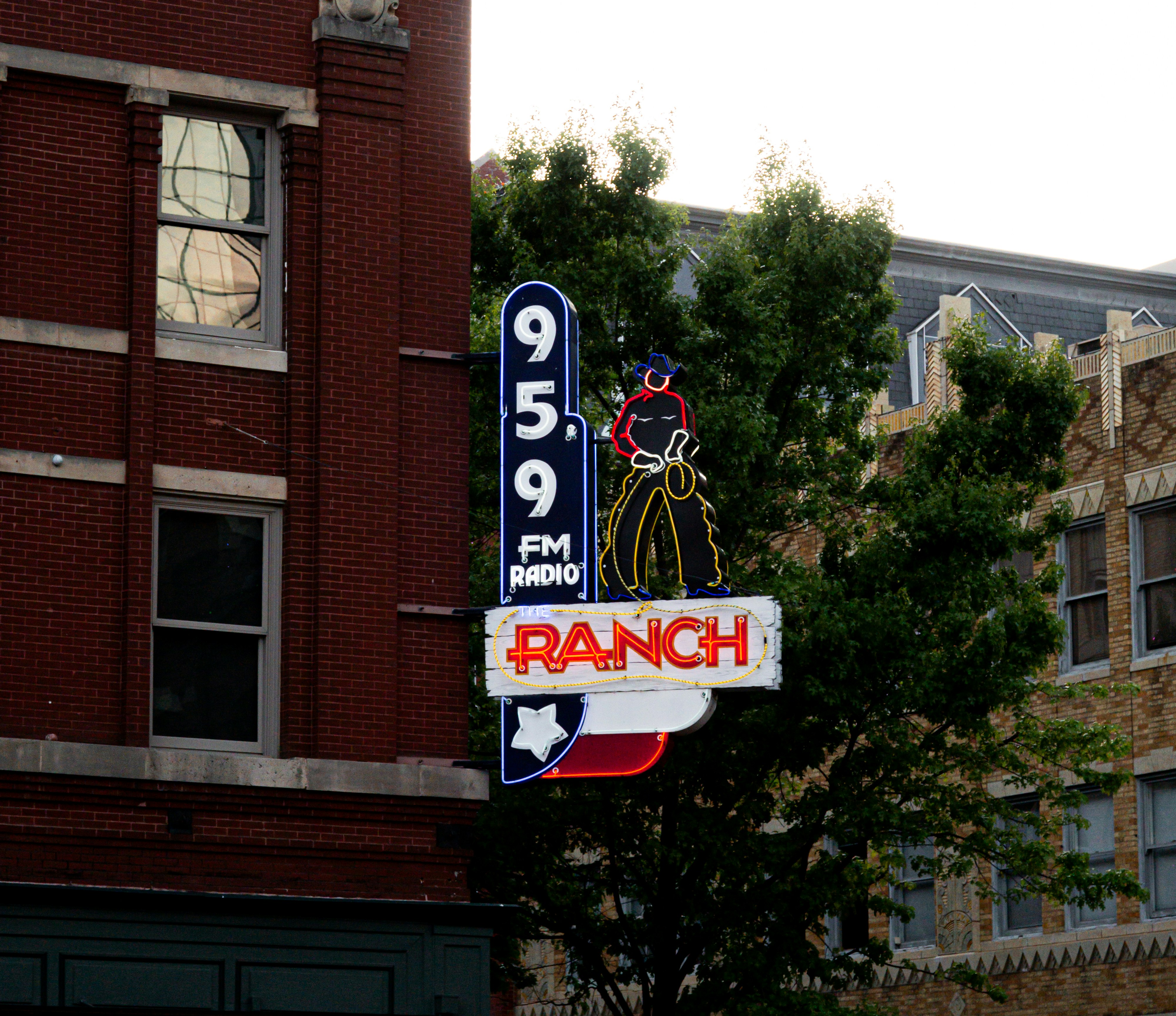 Neon Ranch Sign Piercing the City Bloom