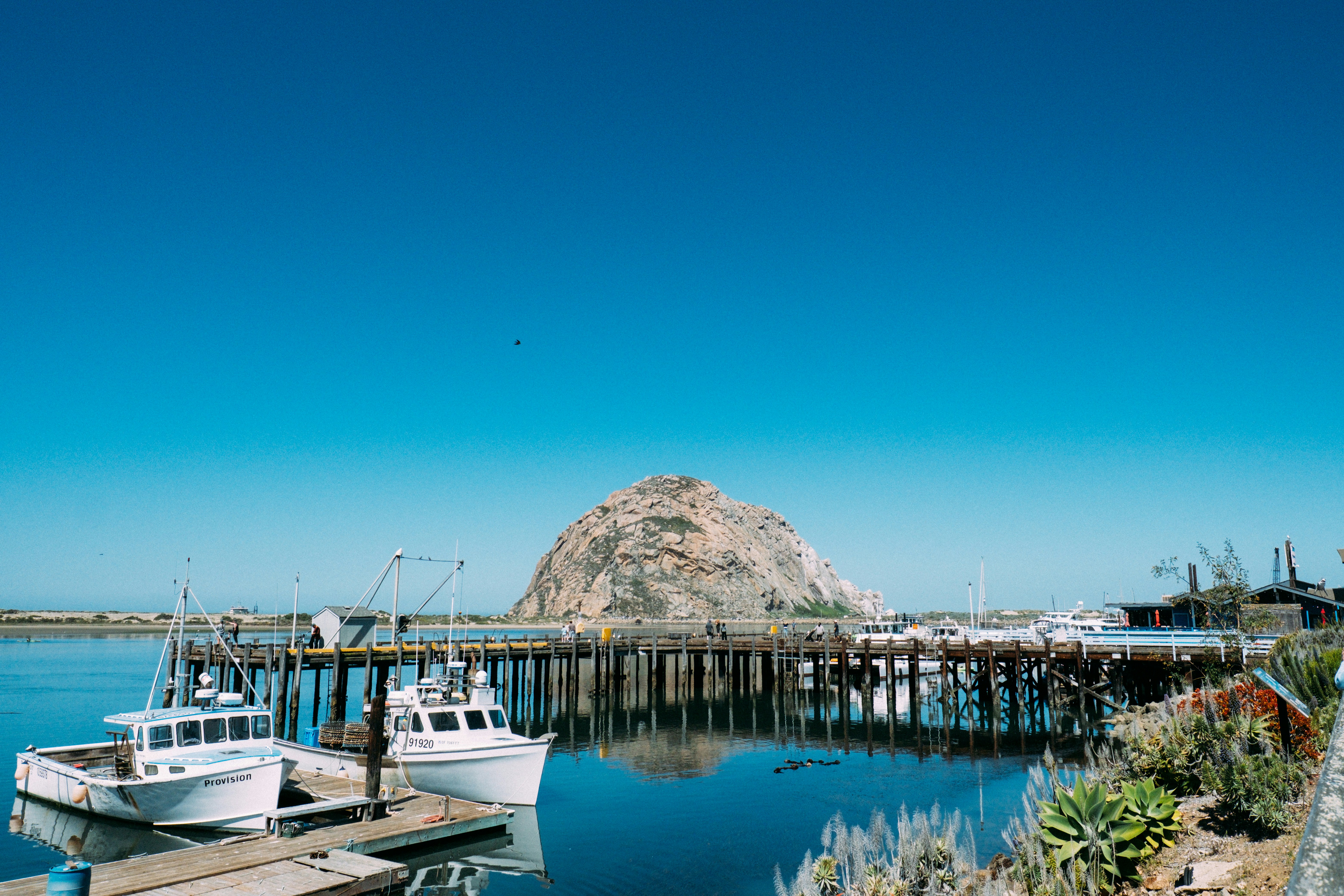 Harbor Mirror: Boats, Pier, and a Distant Granite Dome