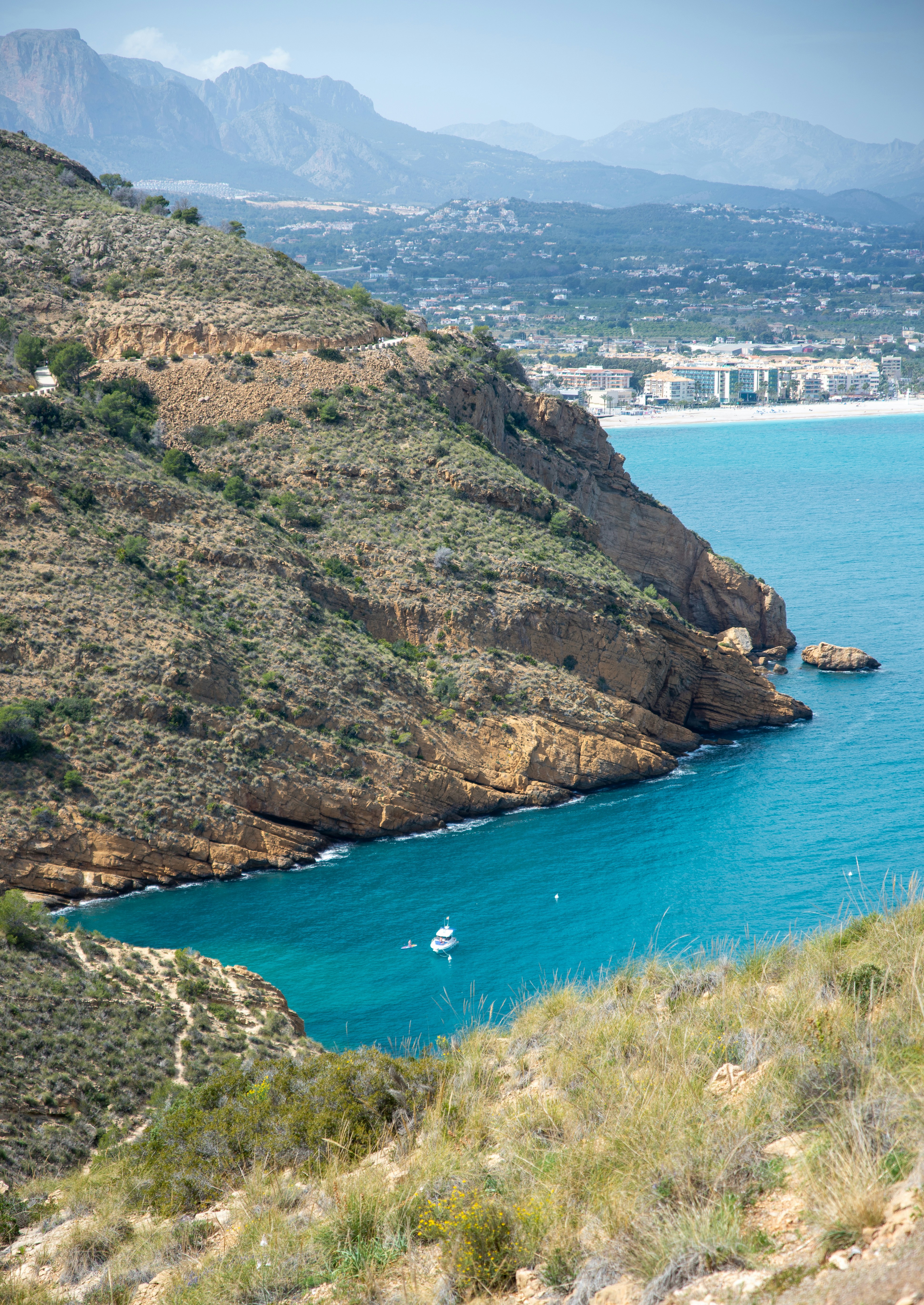Sunlit Cove: A Cliffside Panorama Over Turquoise Seas