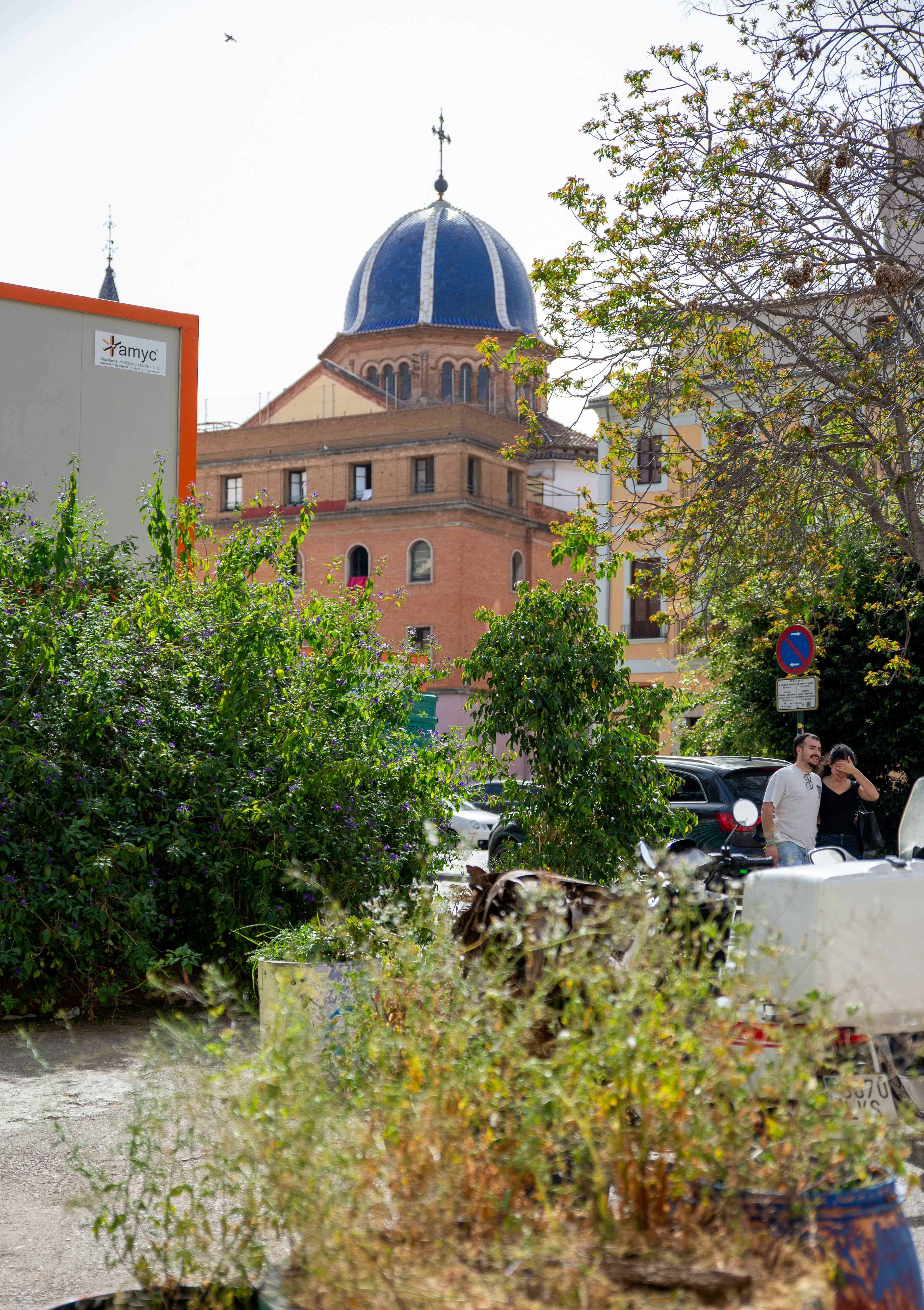 Blue Dome on Brick Facade: Urban Scene with Greens and People
