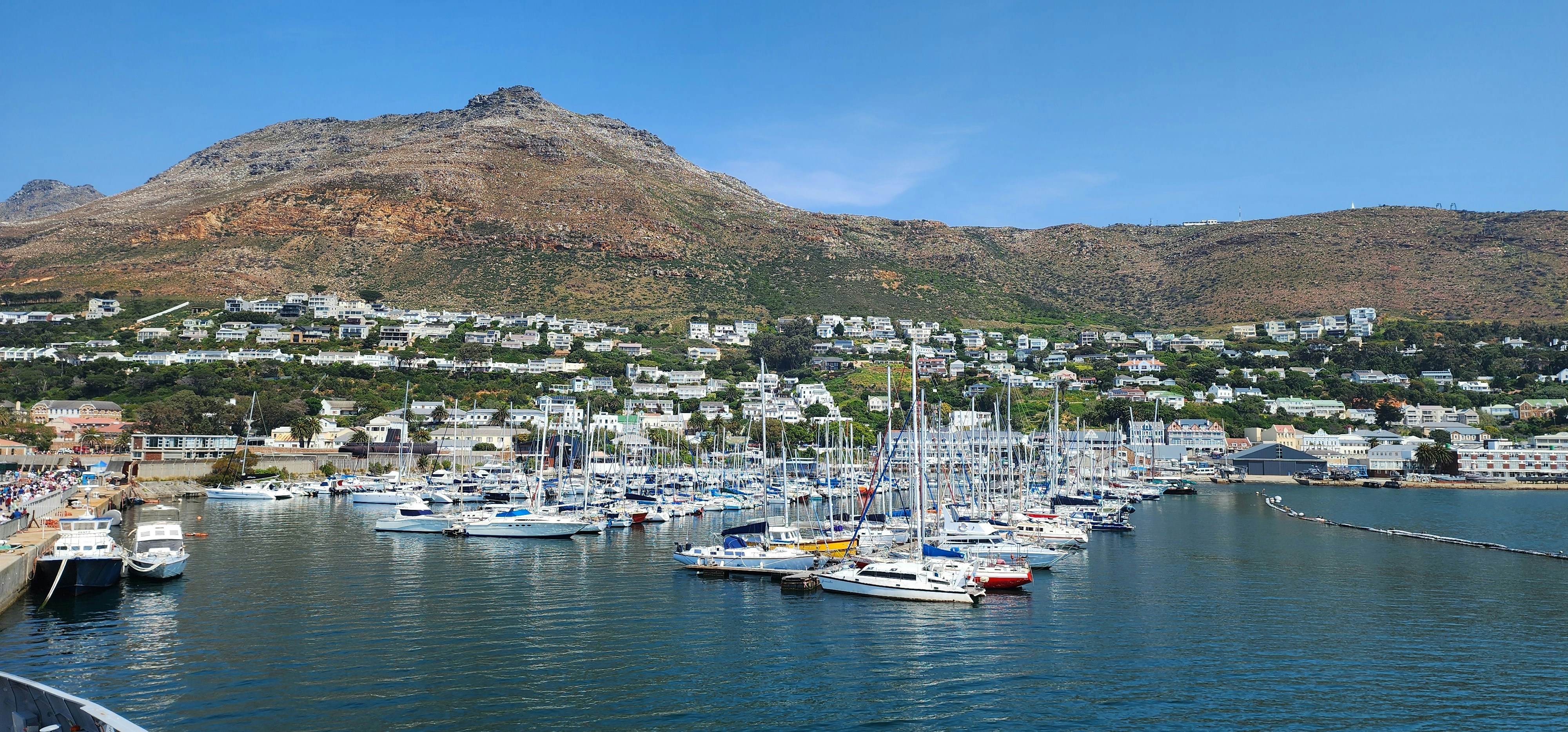 Harbor Tangle: Boats at Rest Along a Sunlit Coastal Village