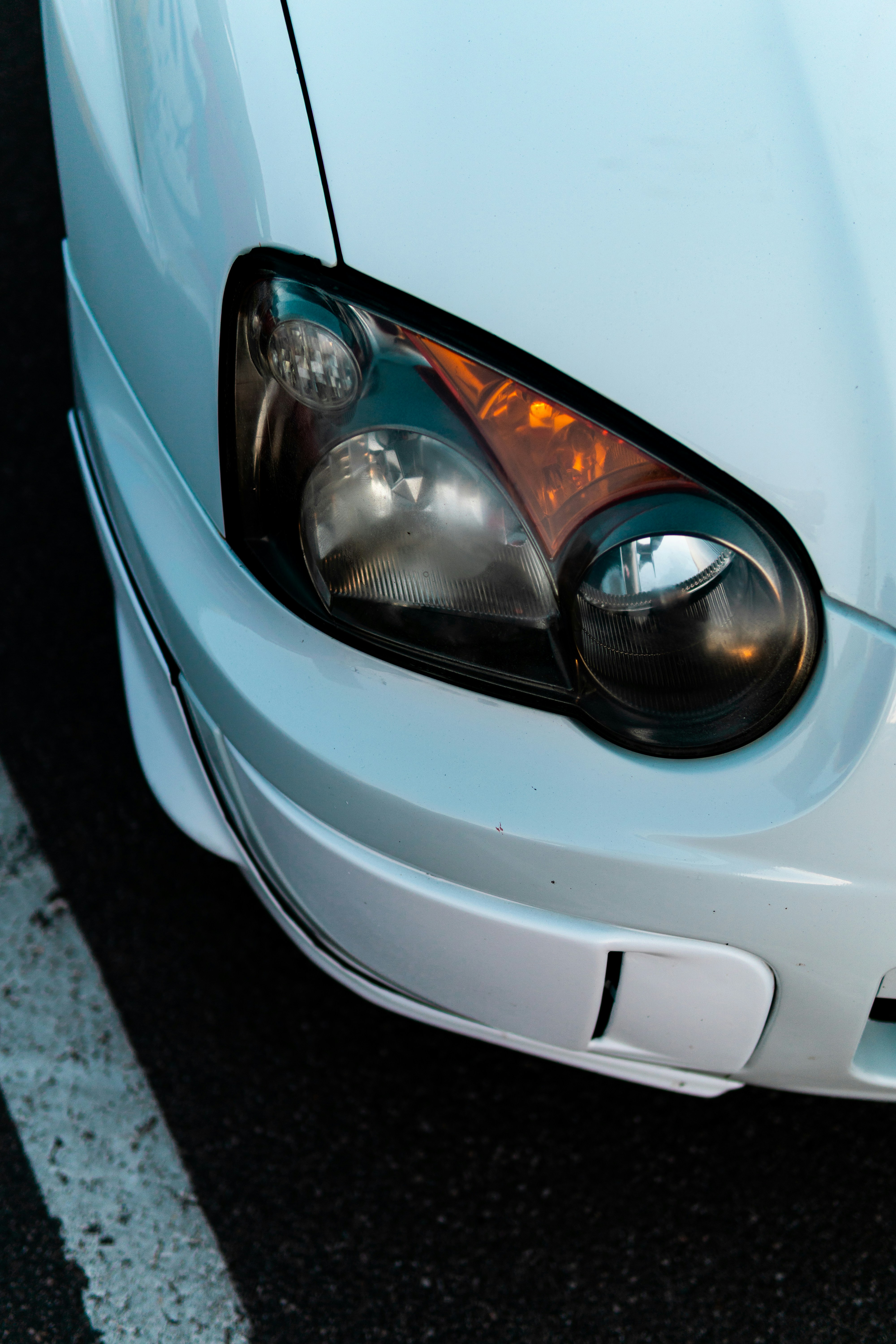 Blue Front Headlight: A Close Cropped Look at a Car's Pale-Tinted Front