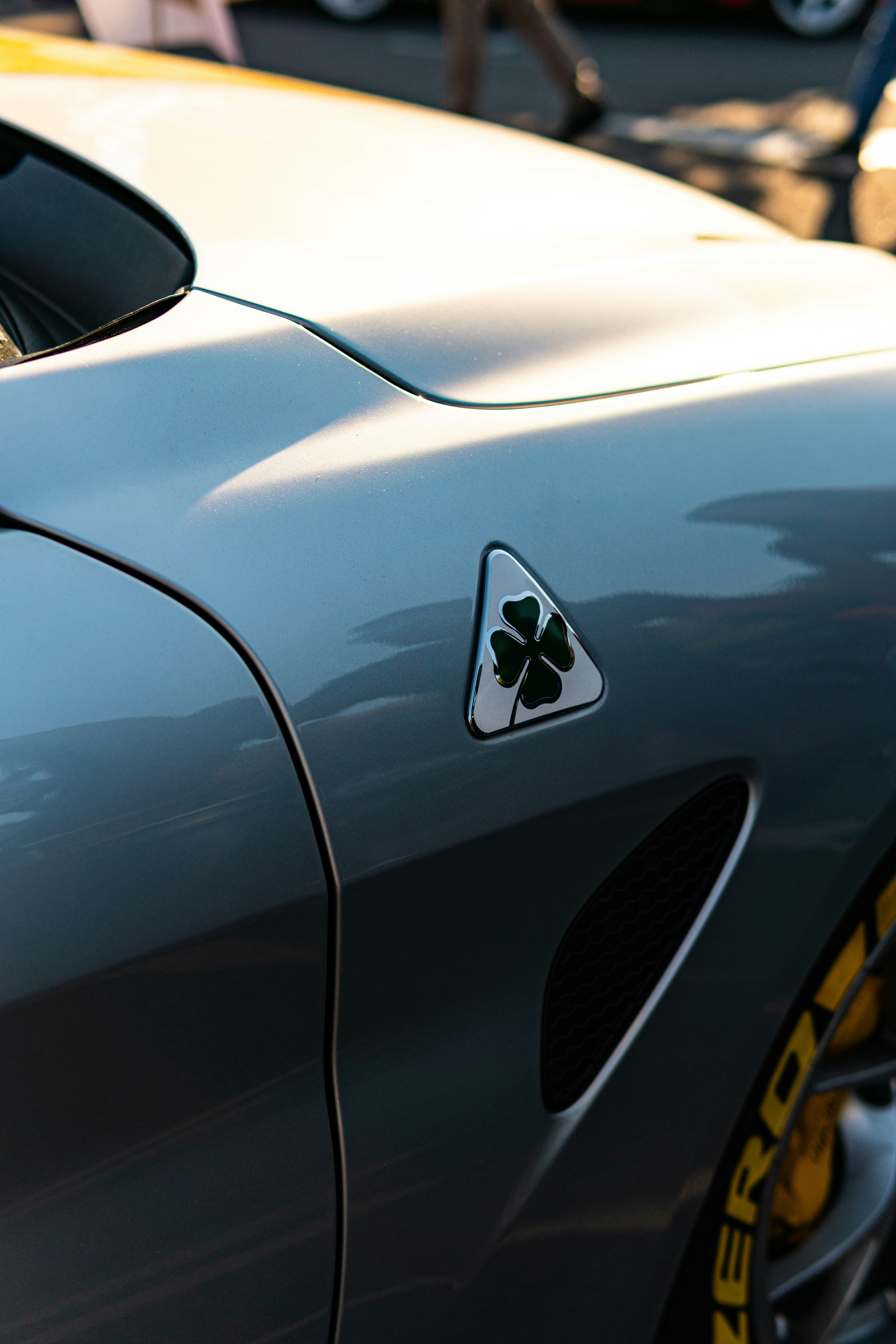 Sleek cobalt hood with clover badge gleaming under streetlight