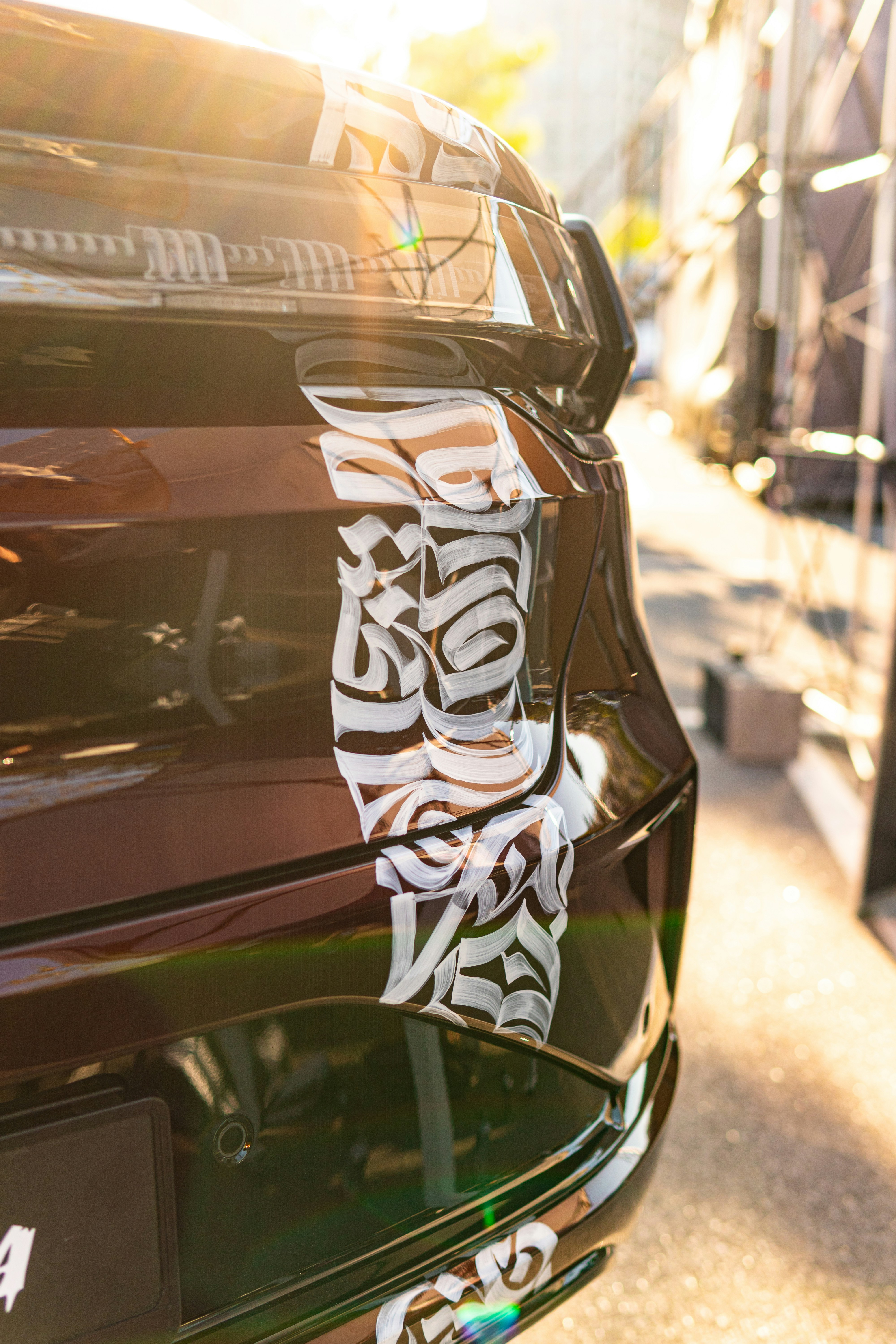  reflected vehicle sculpture: sunlit urban street backdrop