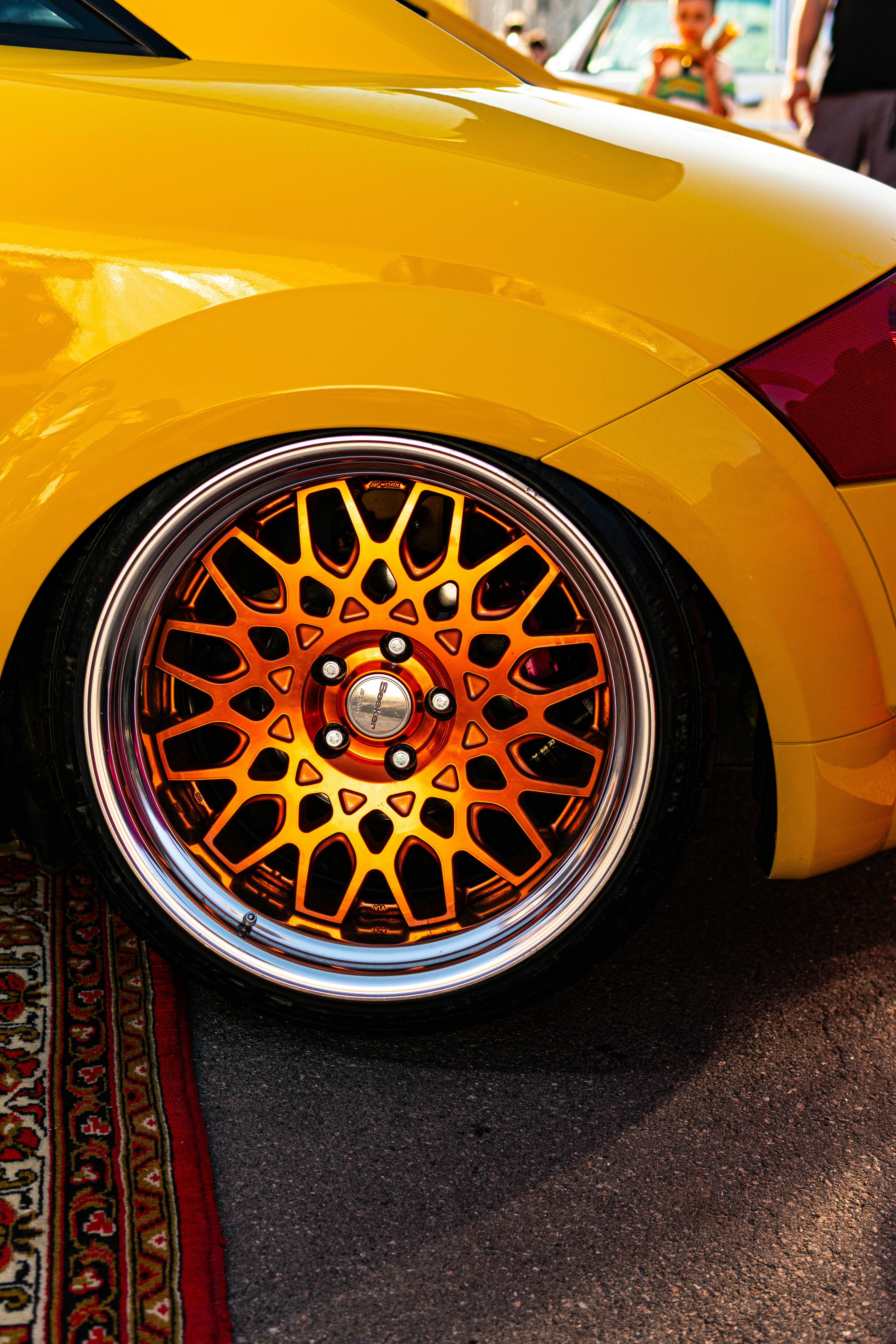 Golden Wheel Interior: a close-up of an intricate gold alloy rim on a yellow sports car