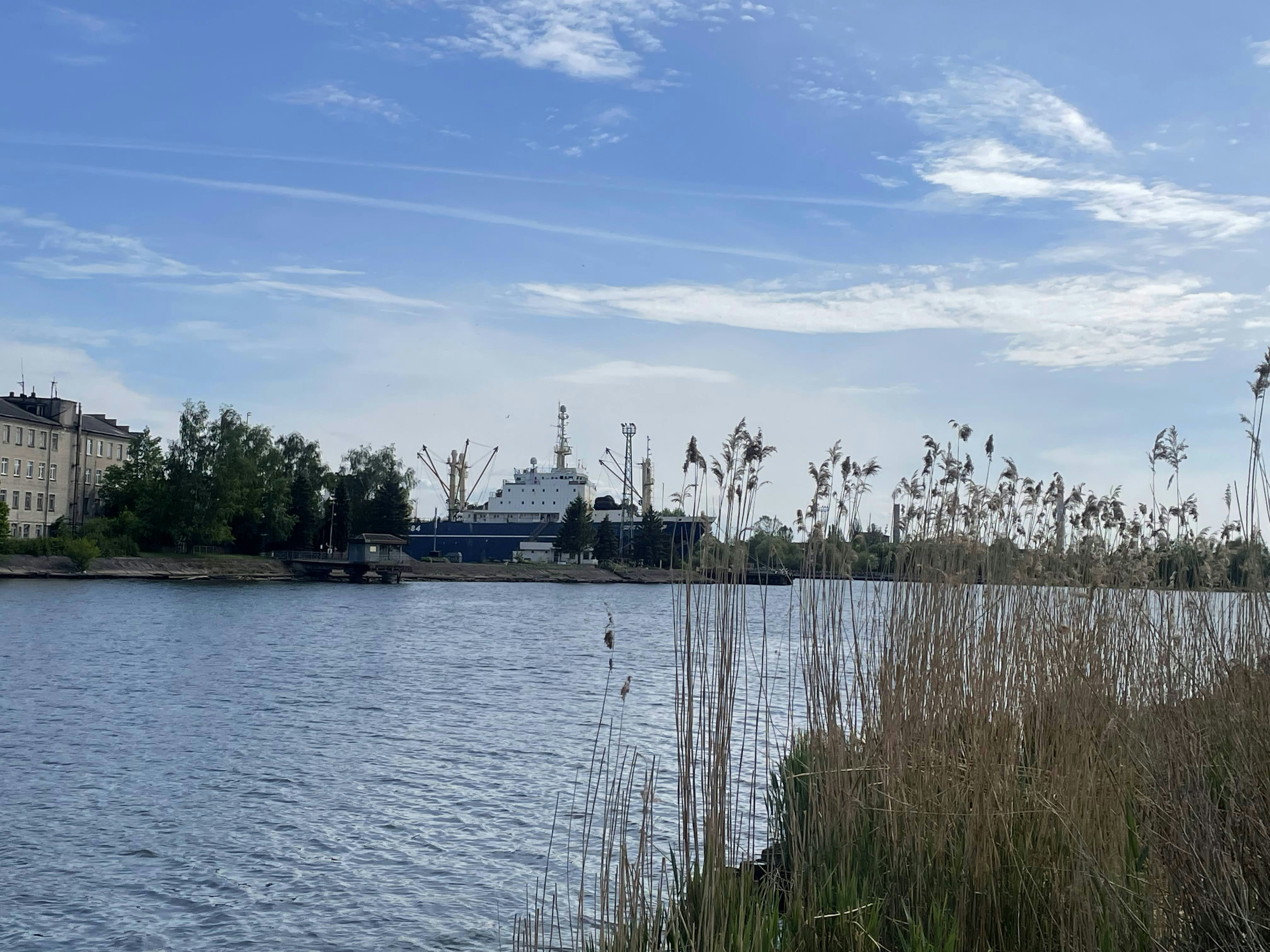 Industrial shoreline beneath a bright afternoon sky