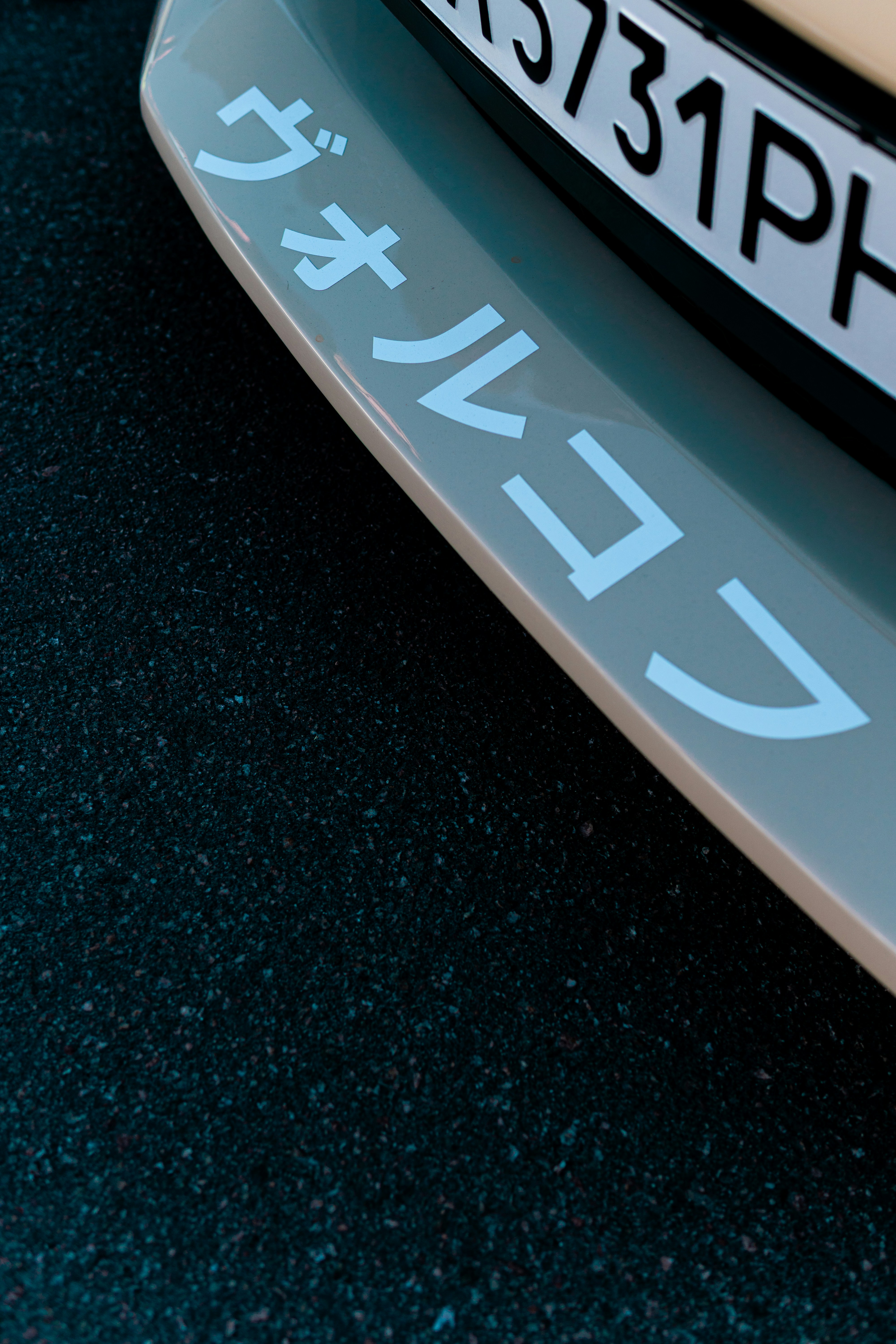 Blue-green bumper with bold Japanese characters and license plate edge
