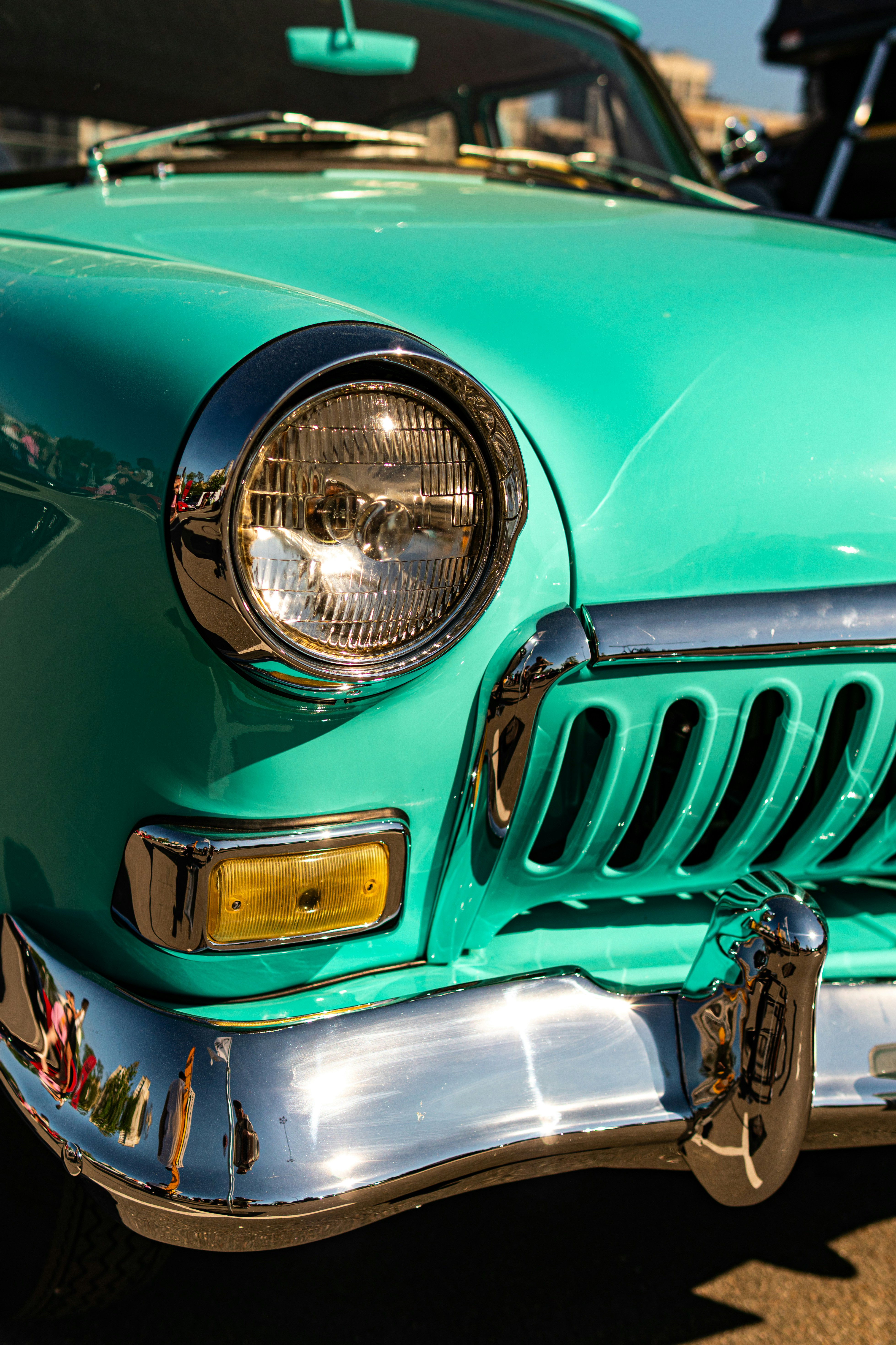Turquoise Classic: A Glinting Front of a Vintage Car