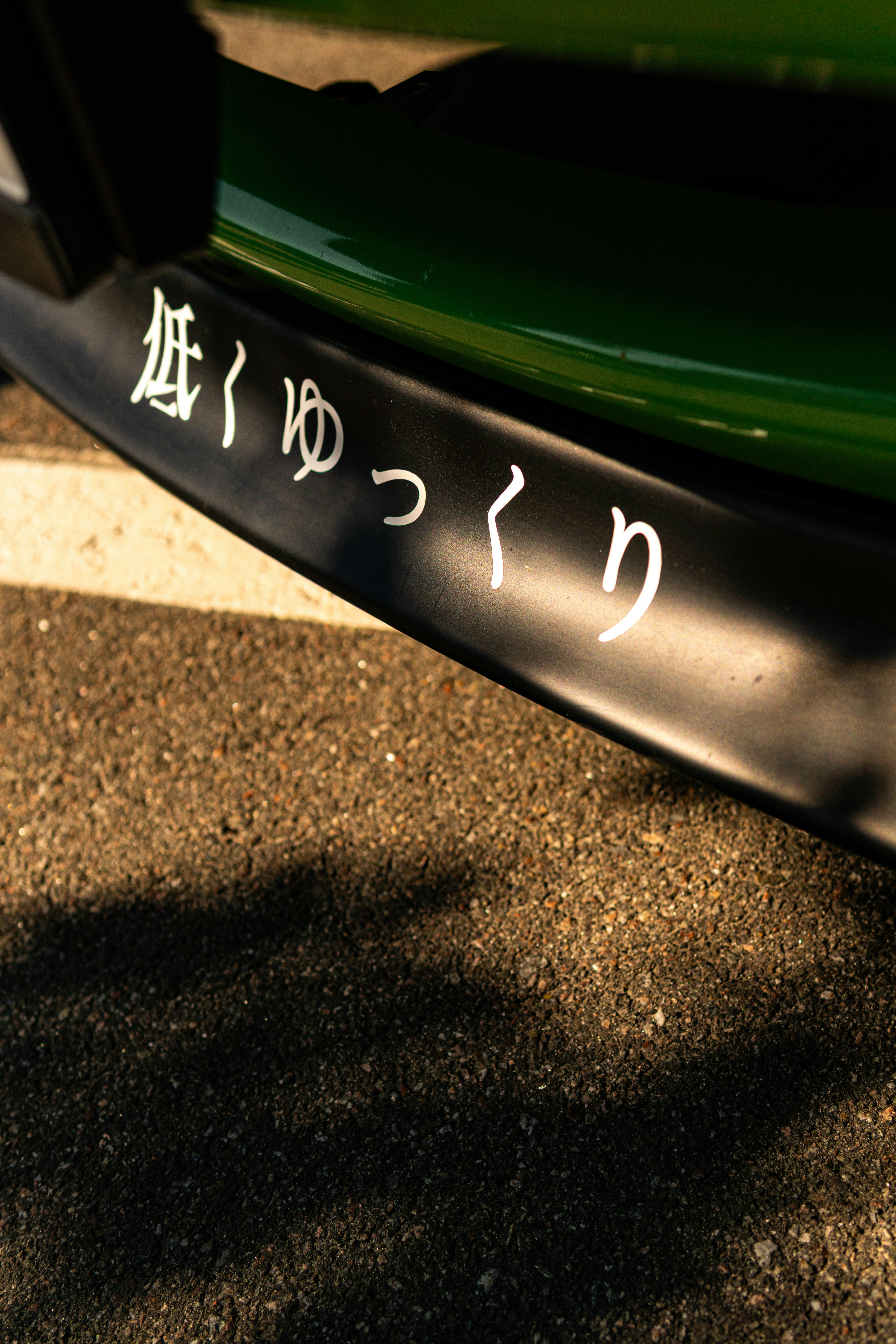 Green Contour and White Japanese Script Along the Car's Front Lip