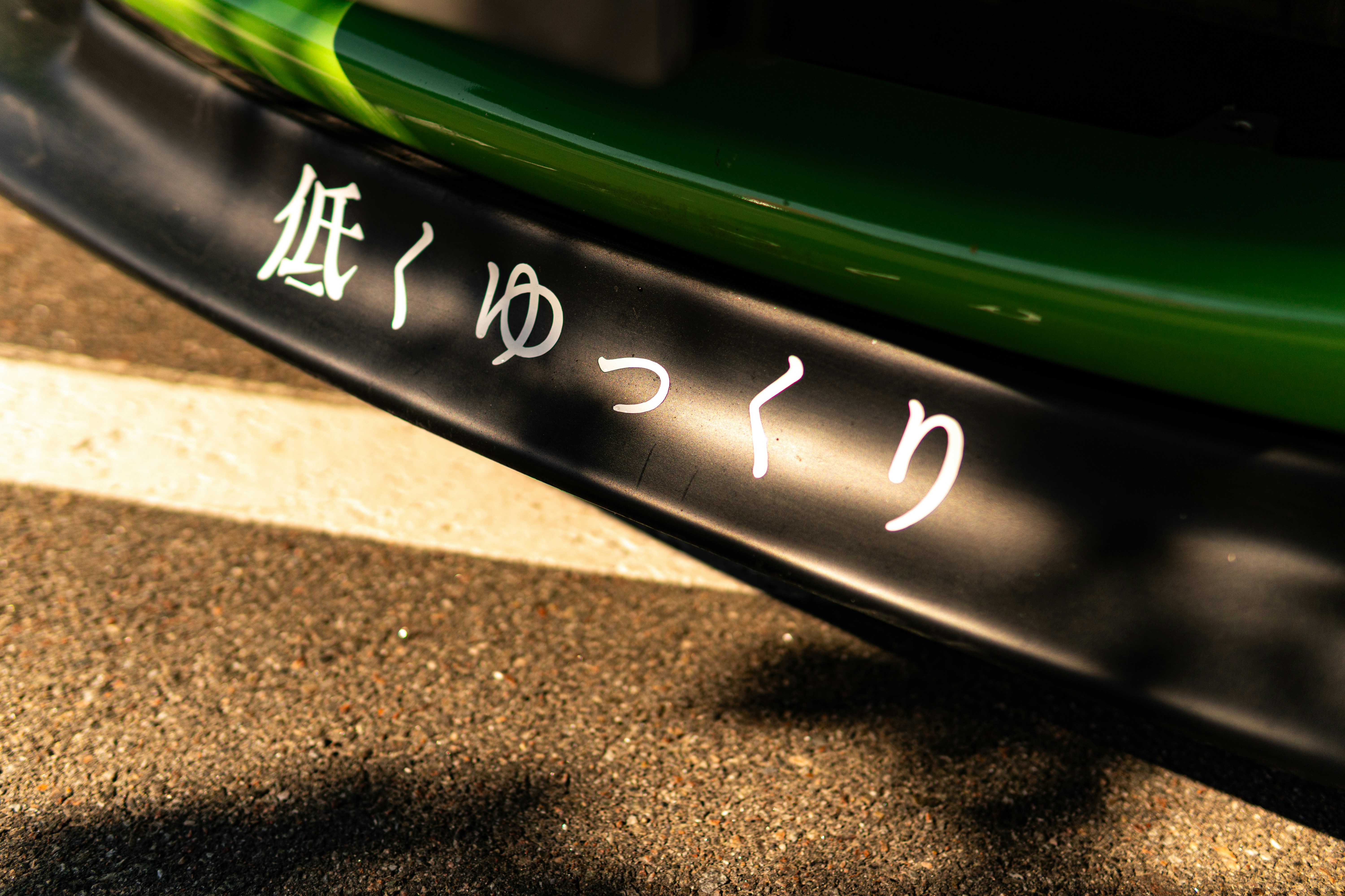 Glossy green edge and white Japanese script on a curved bumper